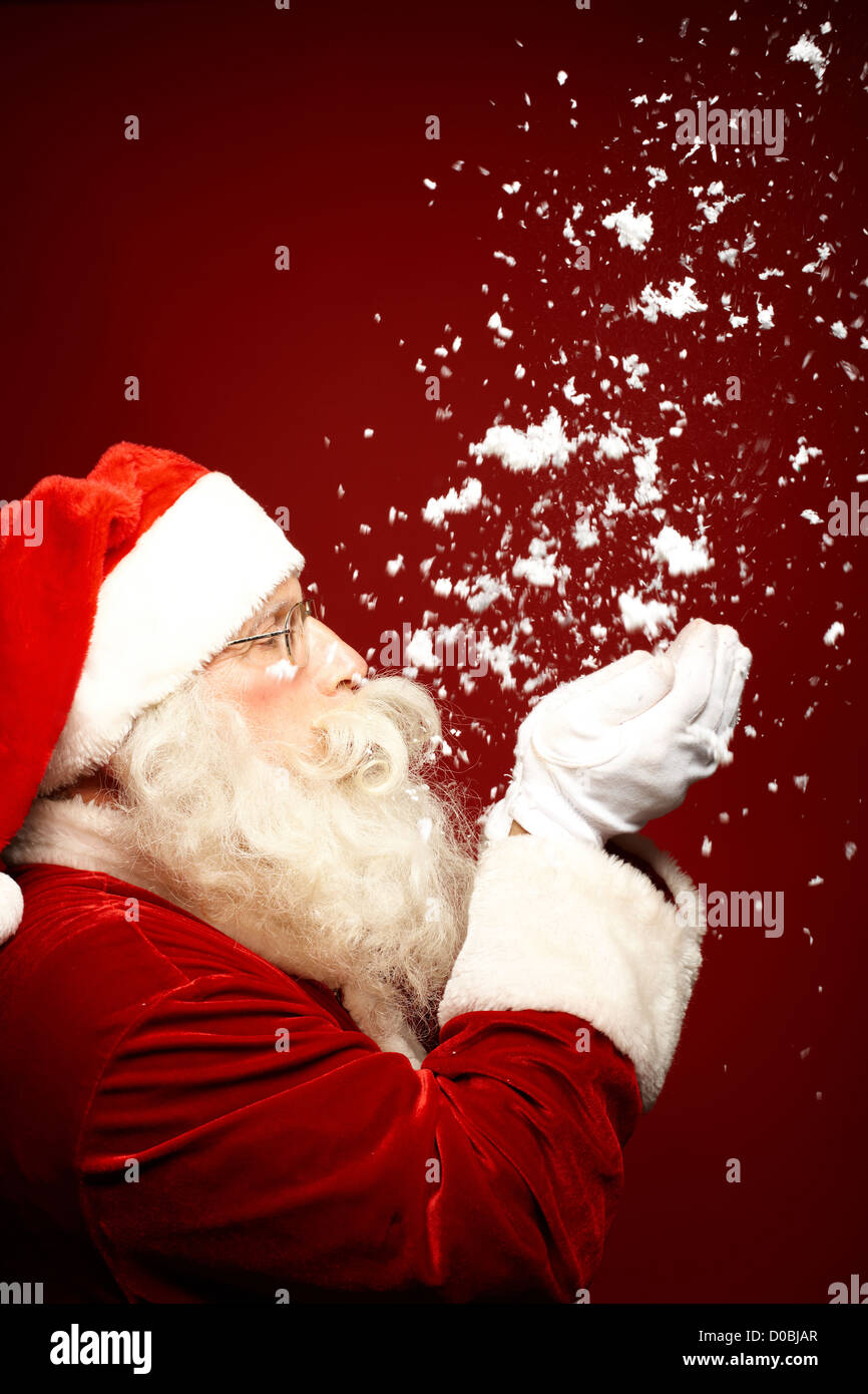 Photo of Santa Claus blowing snow and looking at it Stock Photo - Alamy