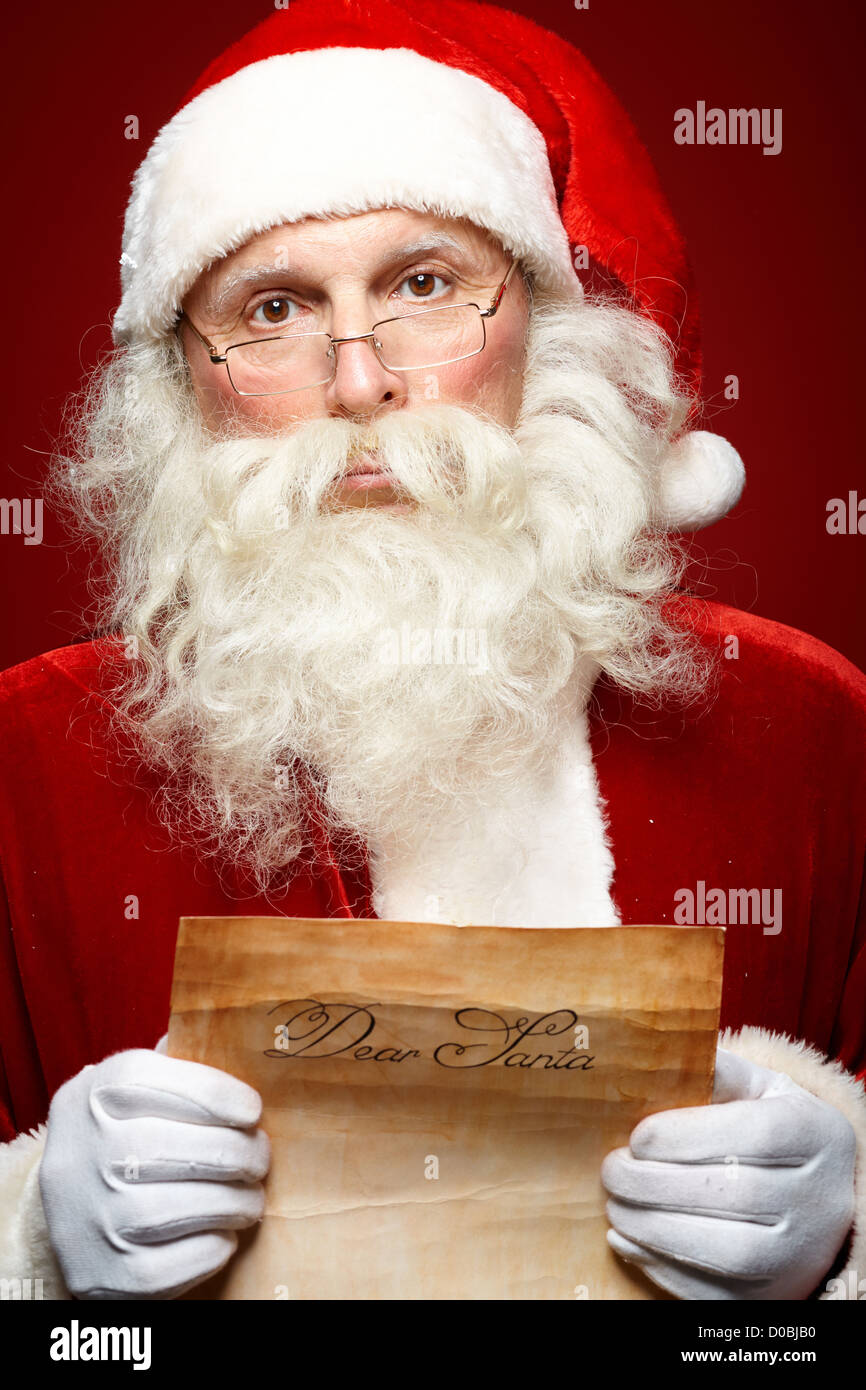 Portrait of Santa Claus holding Christmas letter in his hands and ...