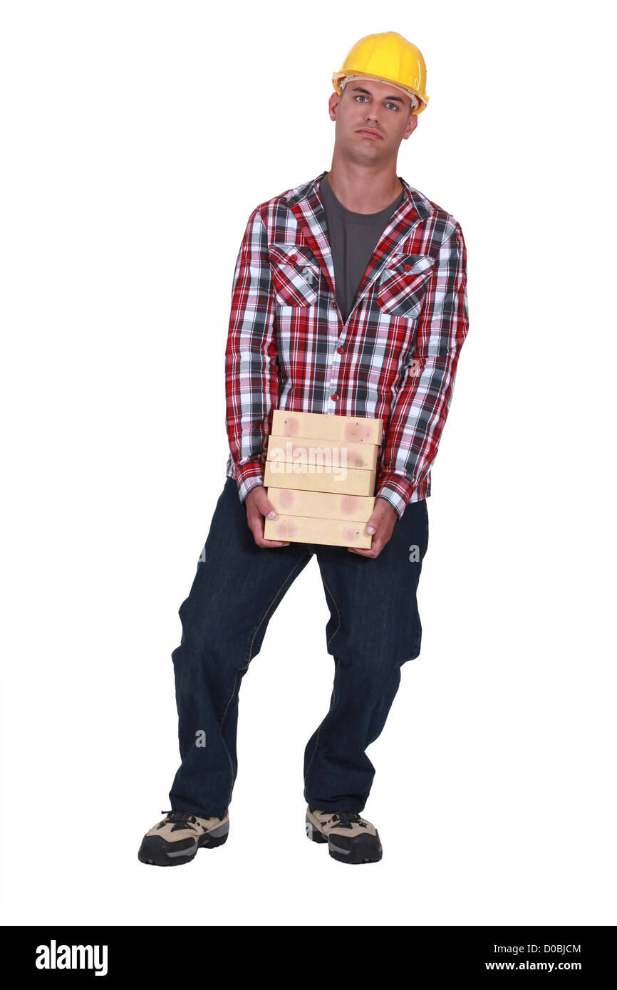Man carrying pile of bricks Stock Photo - Alamy