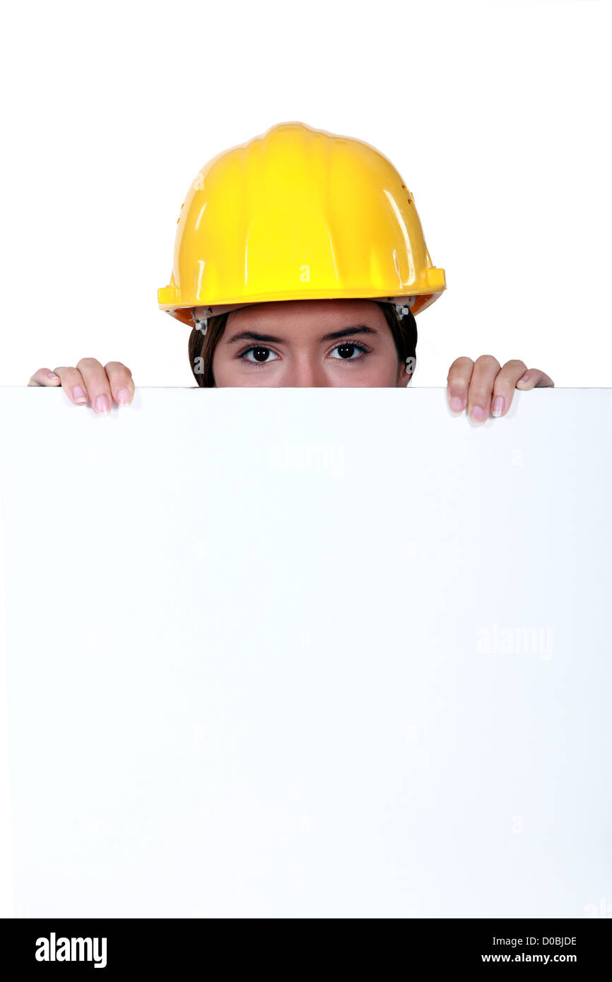 A female construction worker hiding behind a billboard Stock Photo - Alamy
