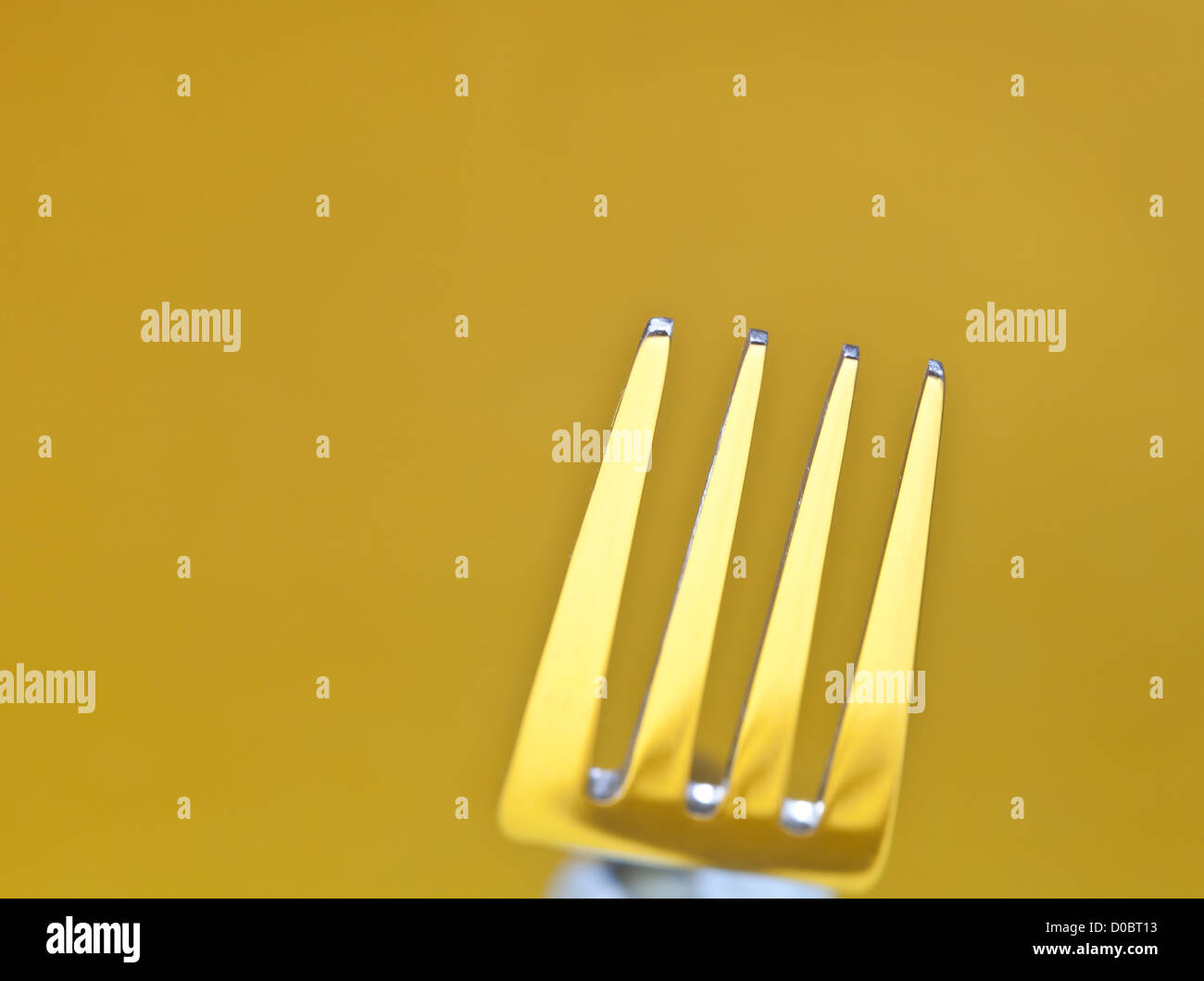 Fork on yellow background Stock Photo - Alamy
