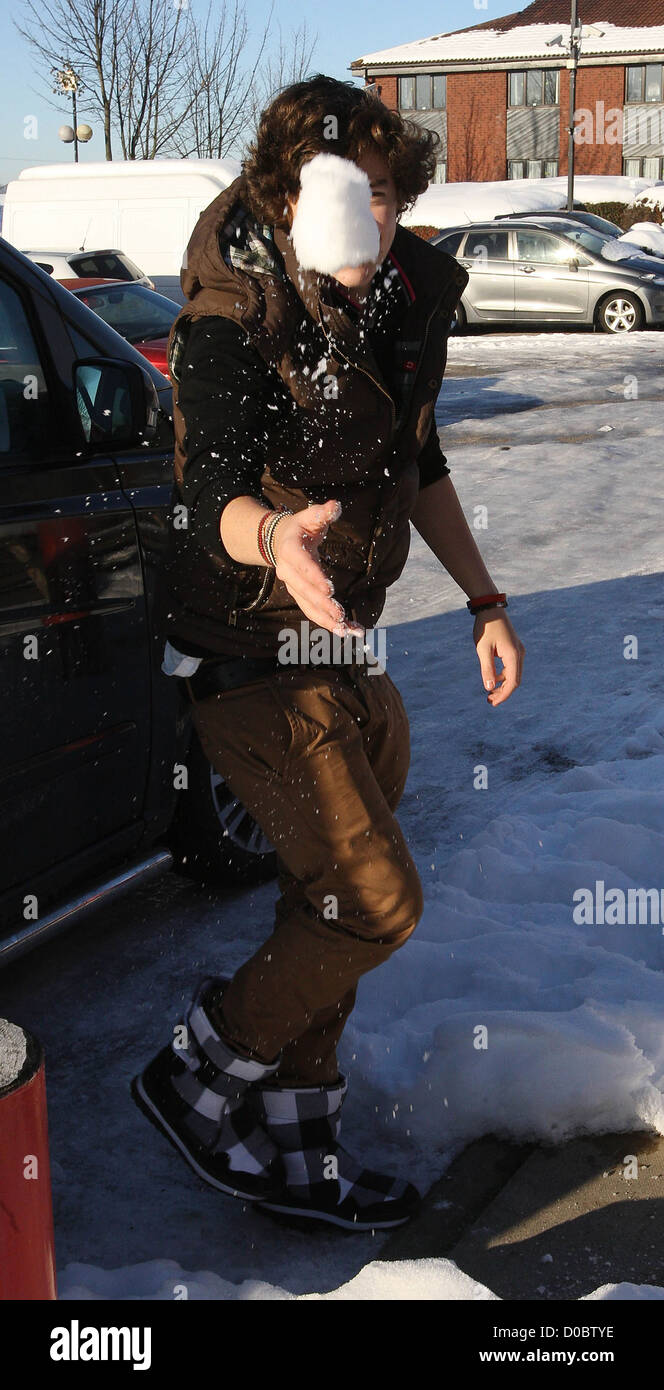 Harry Styles of One Direction throws a snow ball while arriving at ...