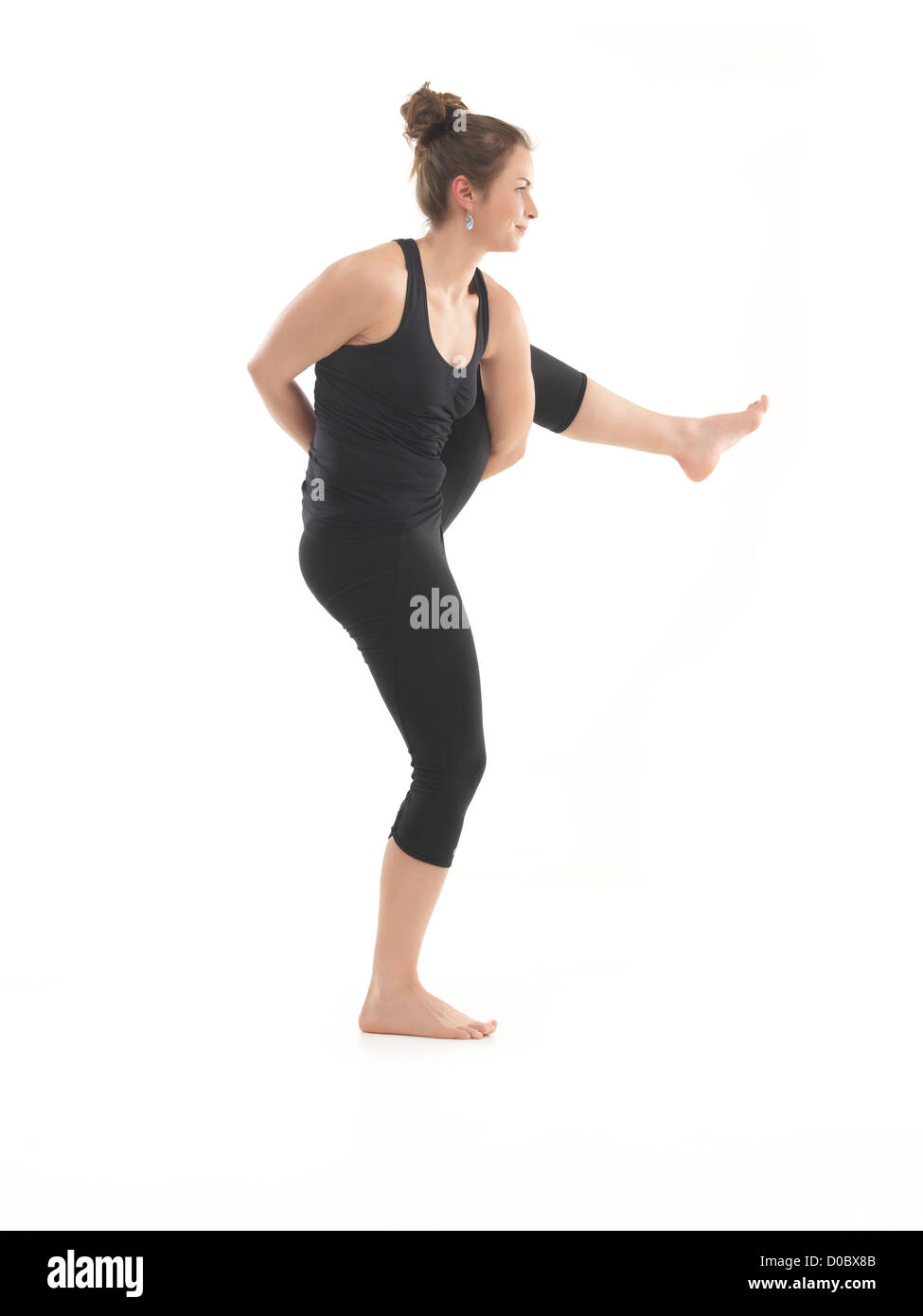 demonstration of balance yoga pose by young woman, dressed in black, on ...