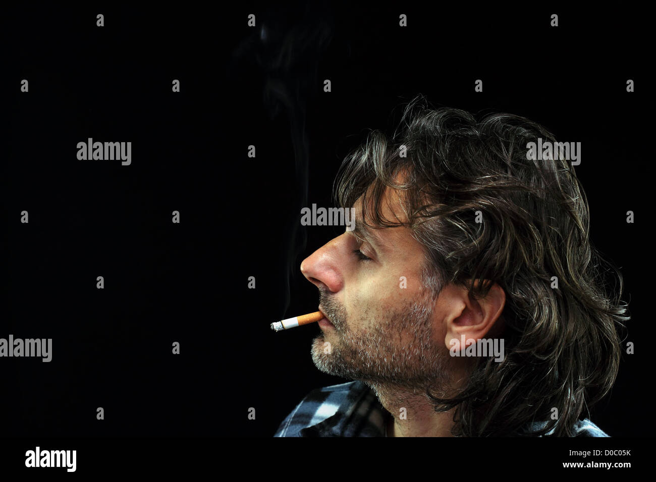 profile of a man smoking cigarette over black Stock Photo - Alamy