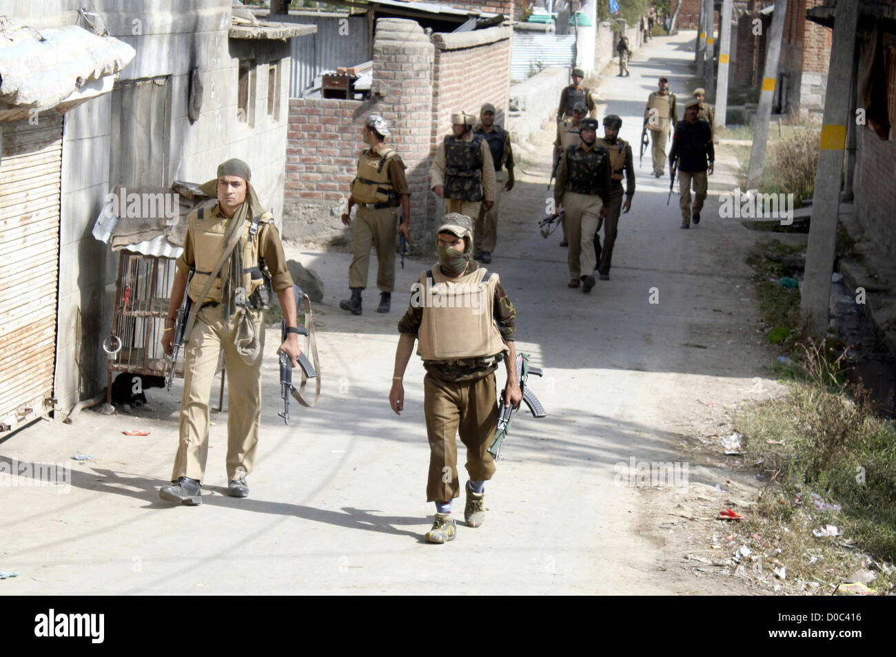Indian Army soldiers take cover behind a wall as they try to storm a ...