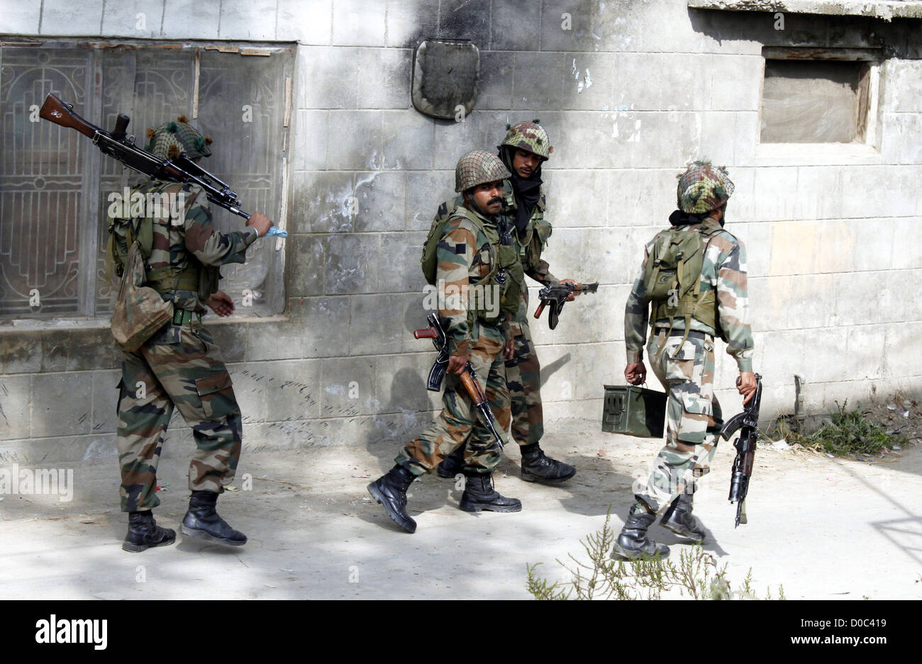 Indian Army soldiers take cover behind a wall as they try to storm a ... Indian Army soldiers take cover behind a wall as they try to storm a ...