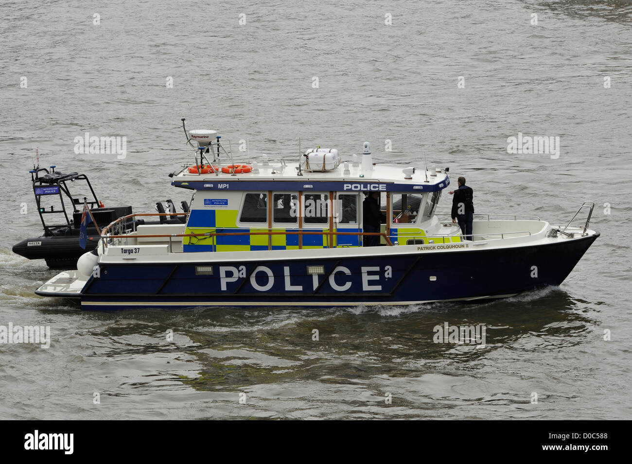 A metropolitan police launch patrols the river Thames in central London ...