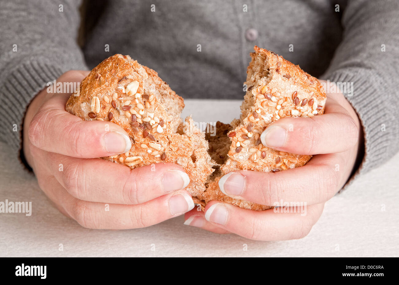 Hands of a woman breaking and sharing bread Stock Photo - Alamy