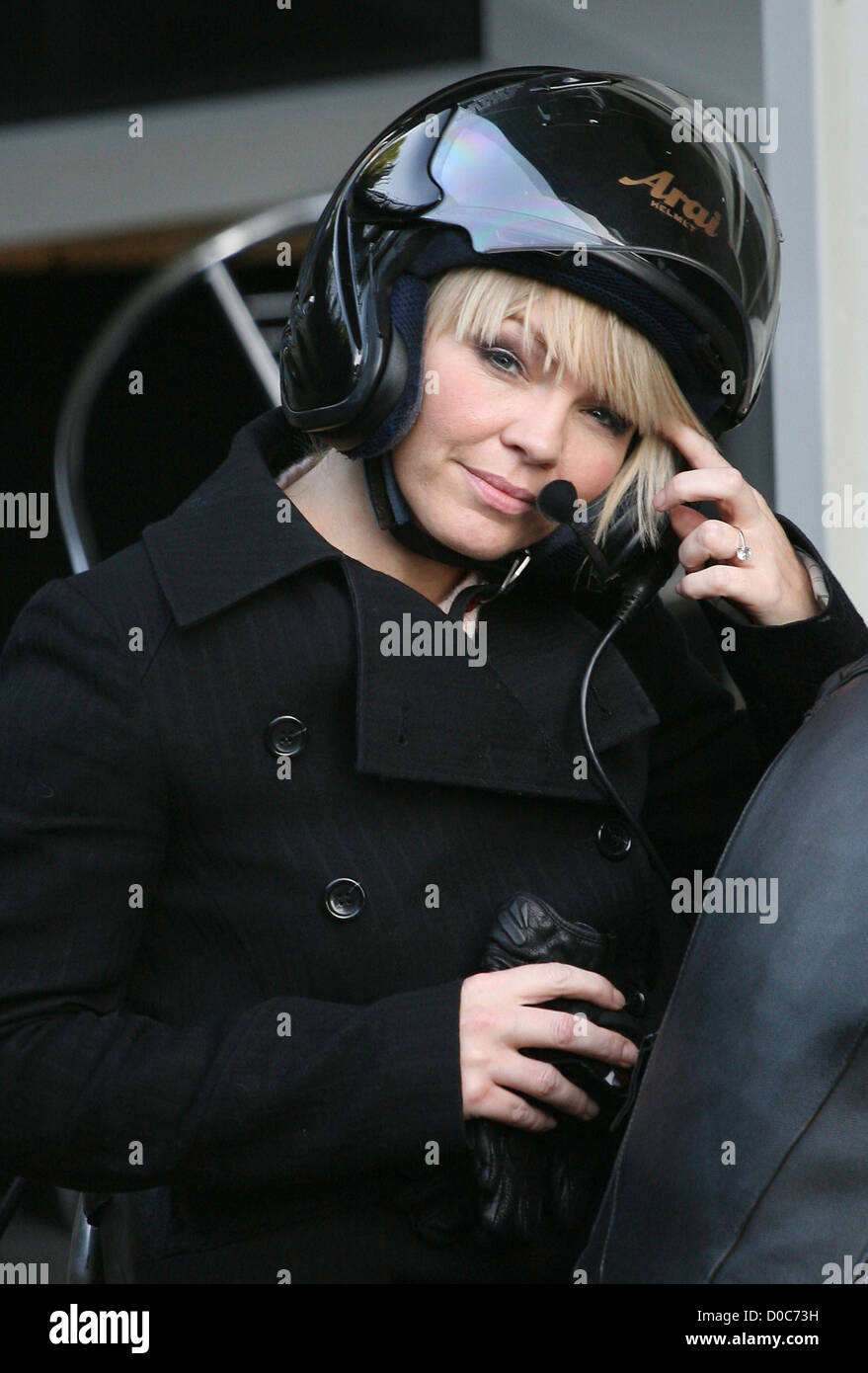 Kate Thornton wearing a motorcycle helmet whilst riding pillion on a ...