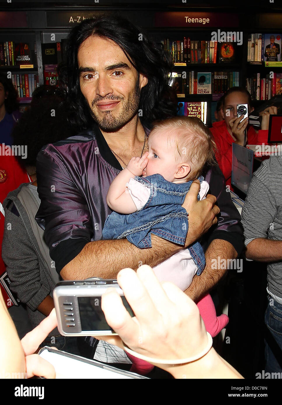 Russell Brand cuddles a baby as he visit's a Waterstone's Book Store to ...