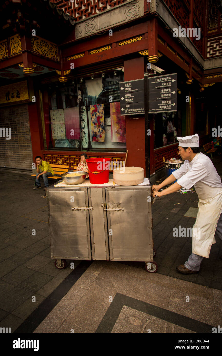 A worker pushes a food cart through the Yu Yuan bazaar in Shanghai ...