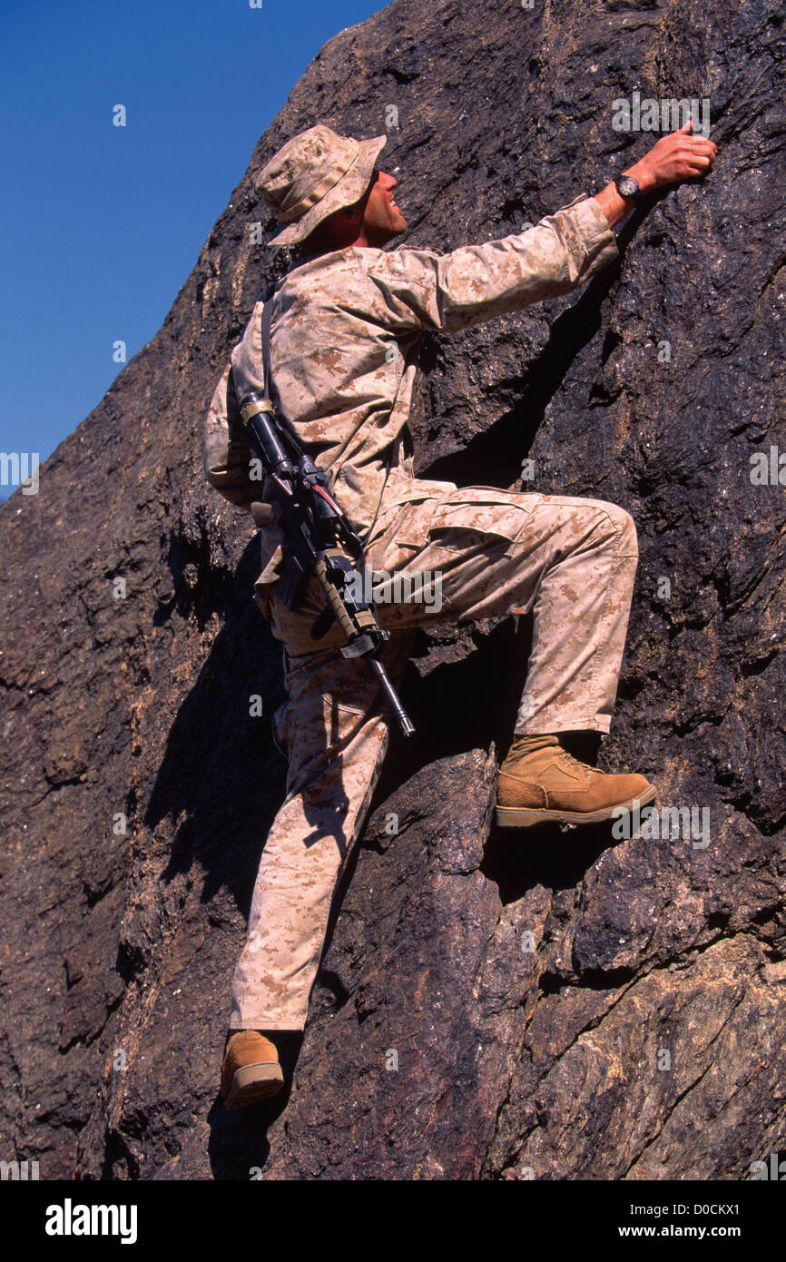 A US Marine Scout Sniper Climbs a Vertical Rock Wall in the Foothills ...