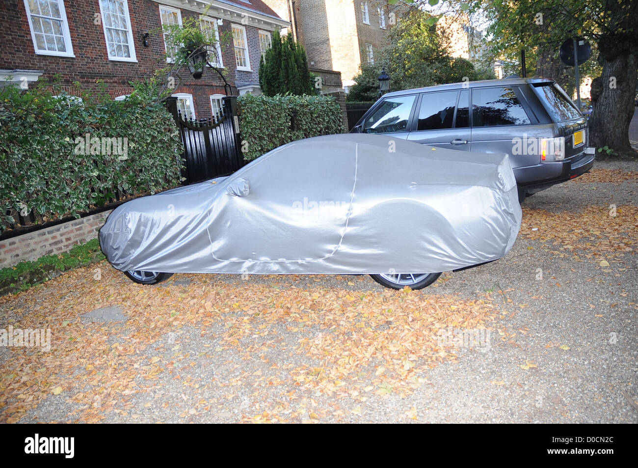 A new sports car with a protective cover over it outside George Michael ...