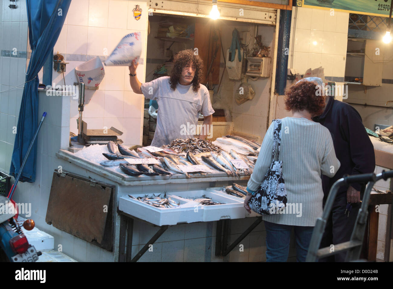 A fishmonger at work in the fish market - a small arcade off the quay ...