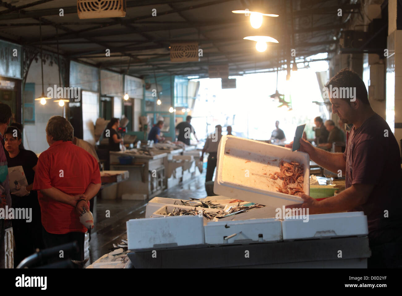 A fishmonger at work in the fish market - a small arcade off the quay ...