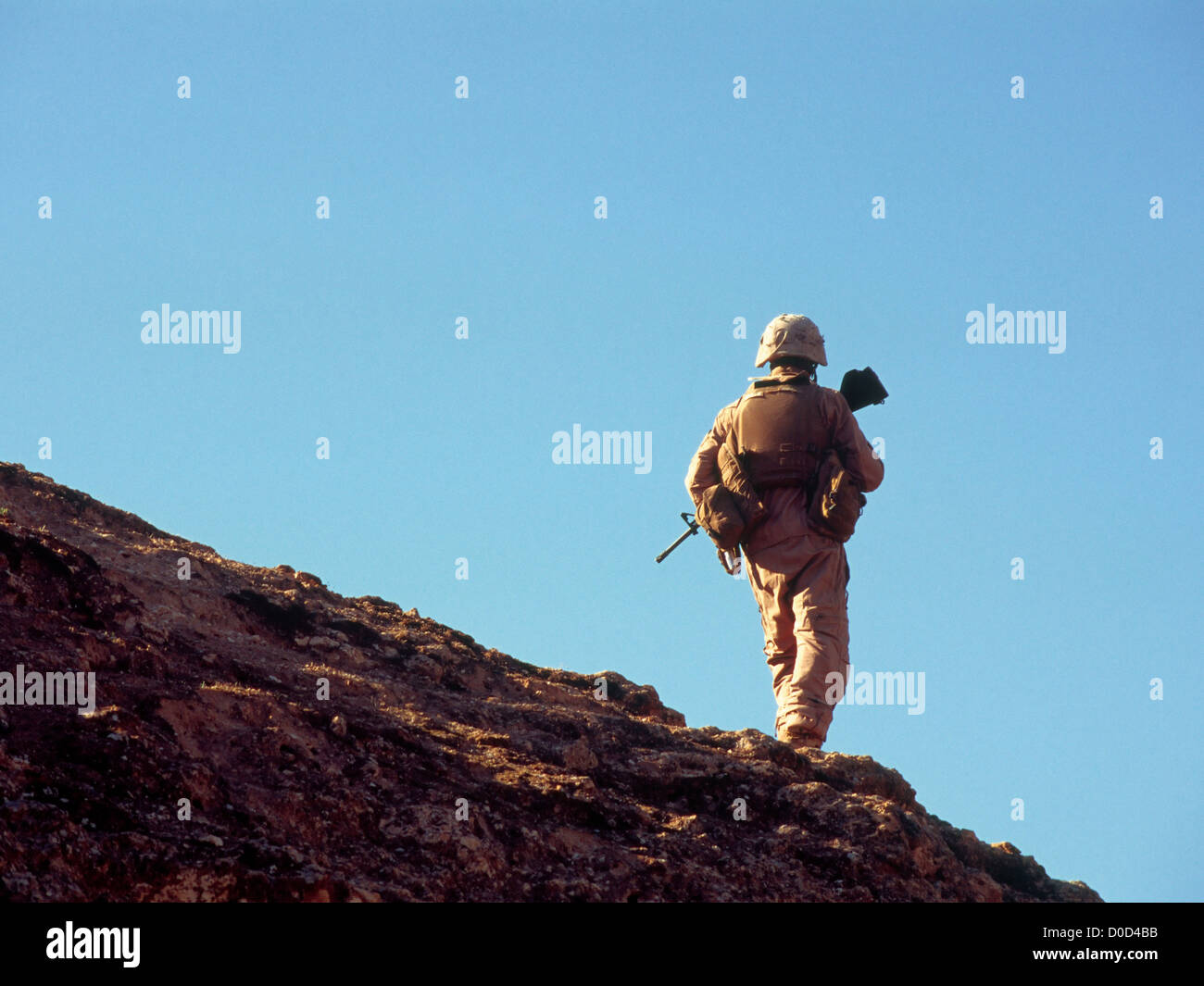 A US Marine on Combat Patrol Walks Along Small Bluff Above Shores ...