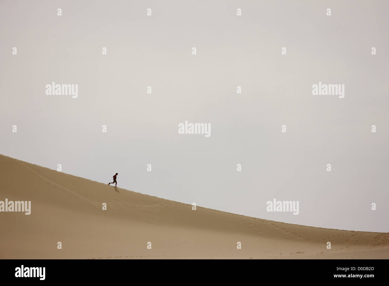 Man Runs Down Long Sand Ridge Stock Photo - Alamy