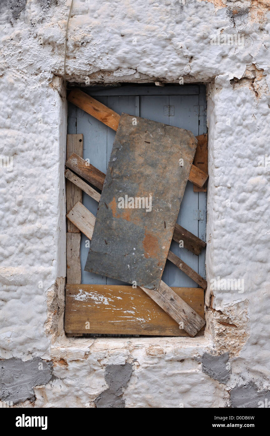 Boarded up window frame of an old house and rough wall background ...