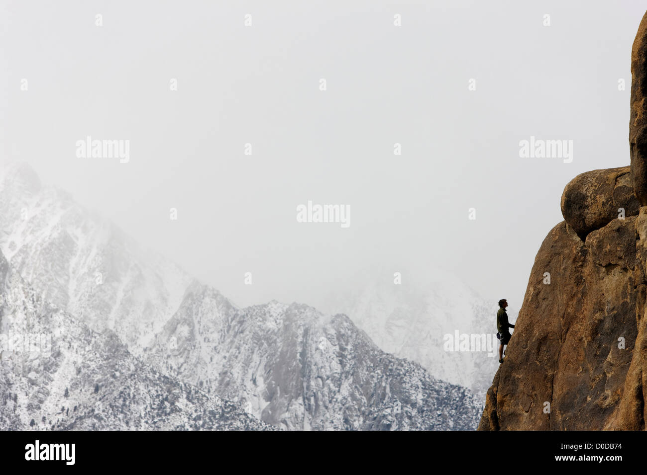 Climber Free Solos Face of a Large Boulder with Storm in the Distance ...