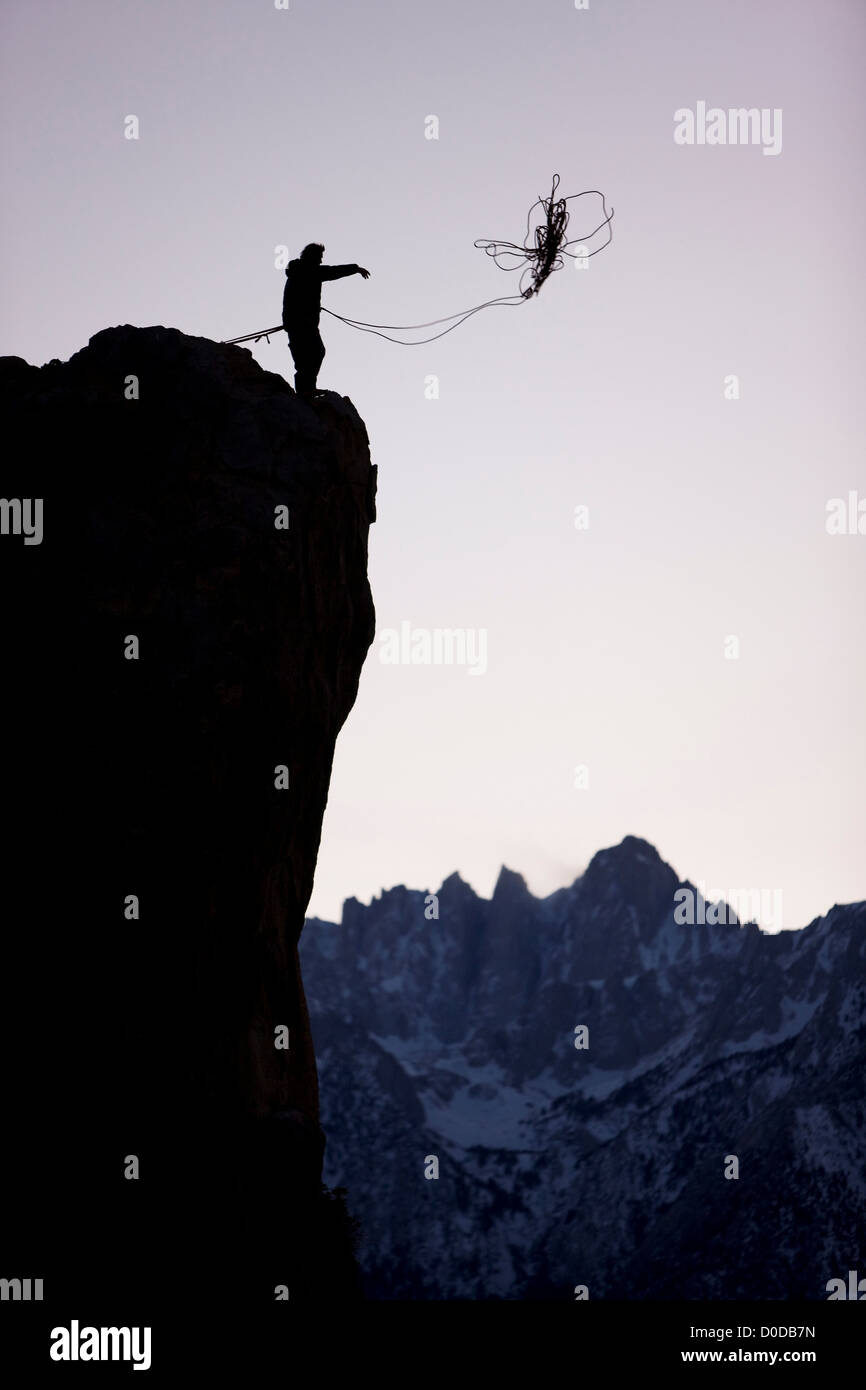 Climber Tosses Rope From Top of Overhanging Cliff Stock Photo - Alamy