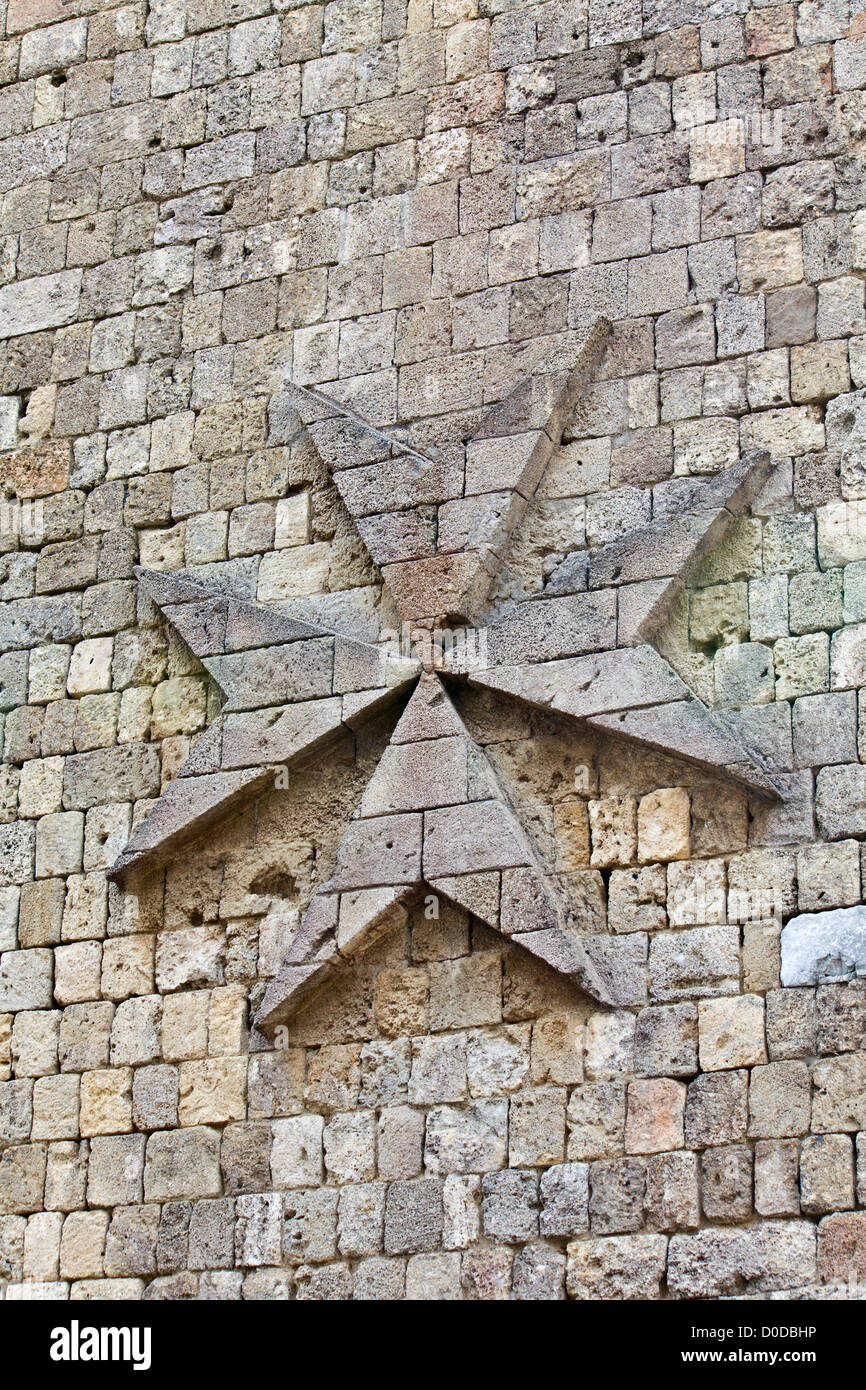 Medieval wall detail image from a castle with the maltese cross on it ...