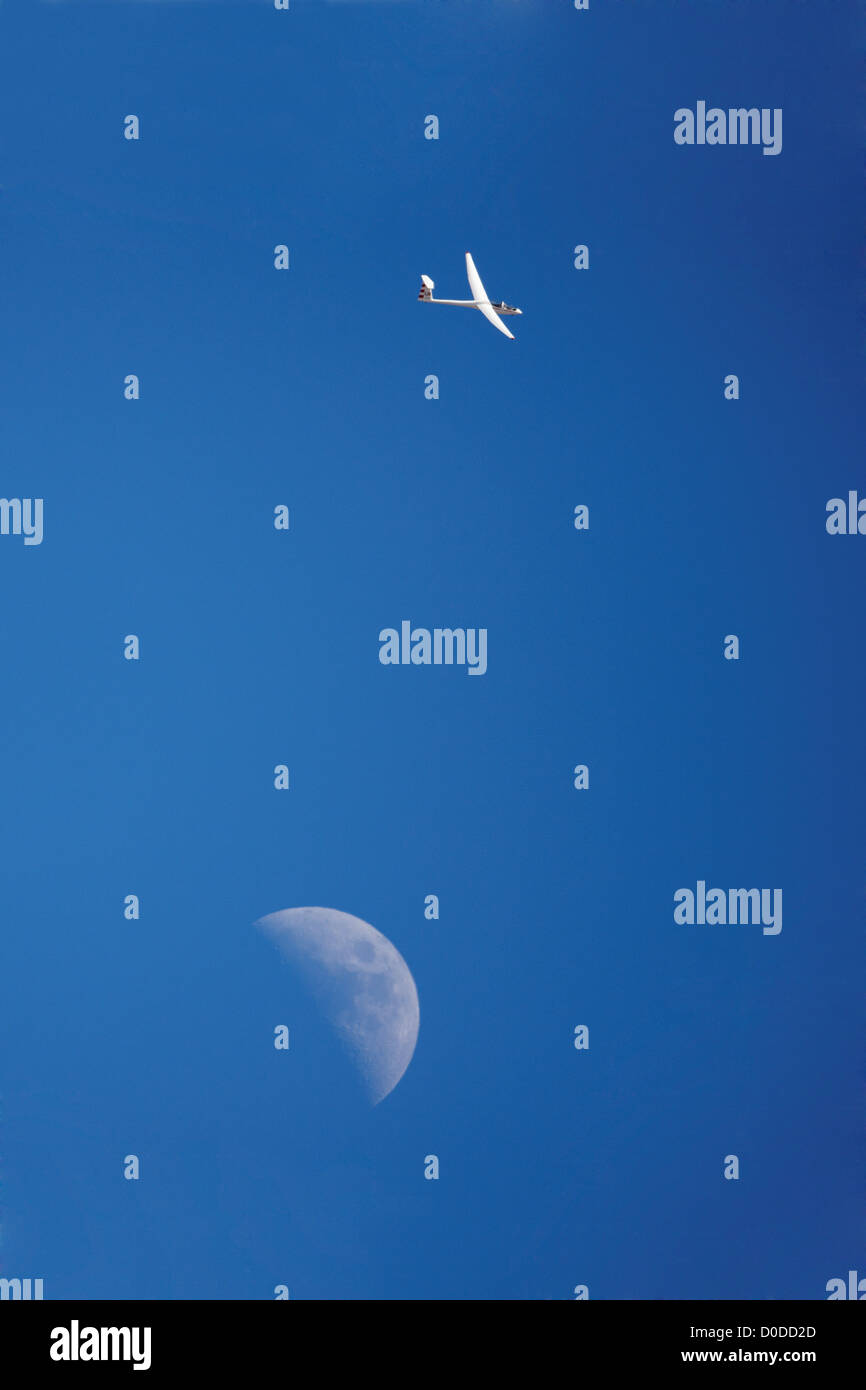 A glider soars above White Mountains California past half moon. Gliders ...