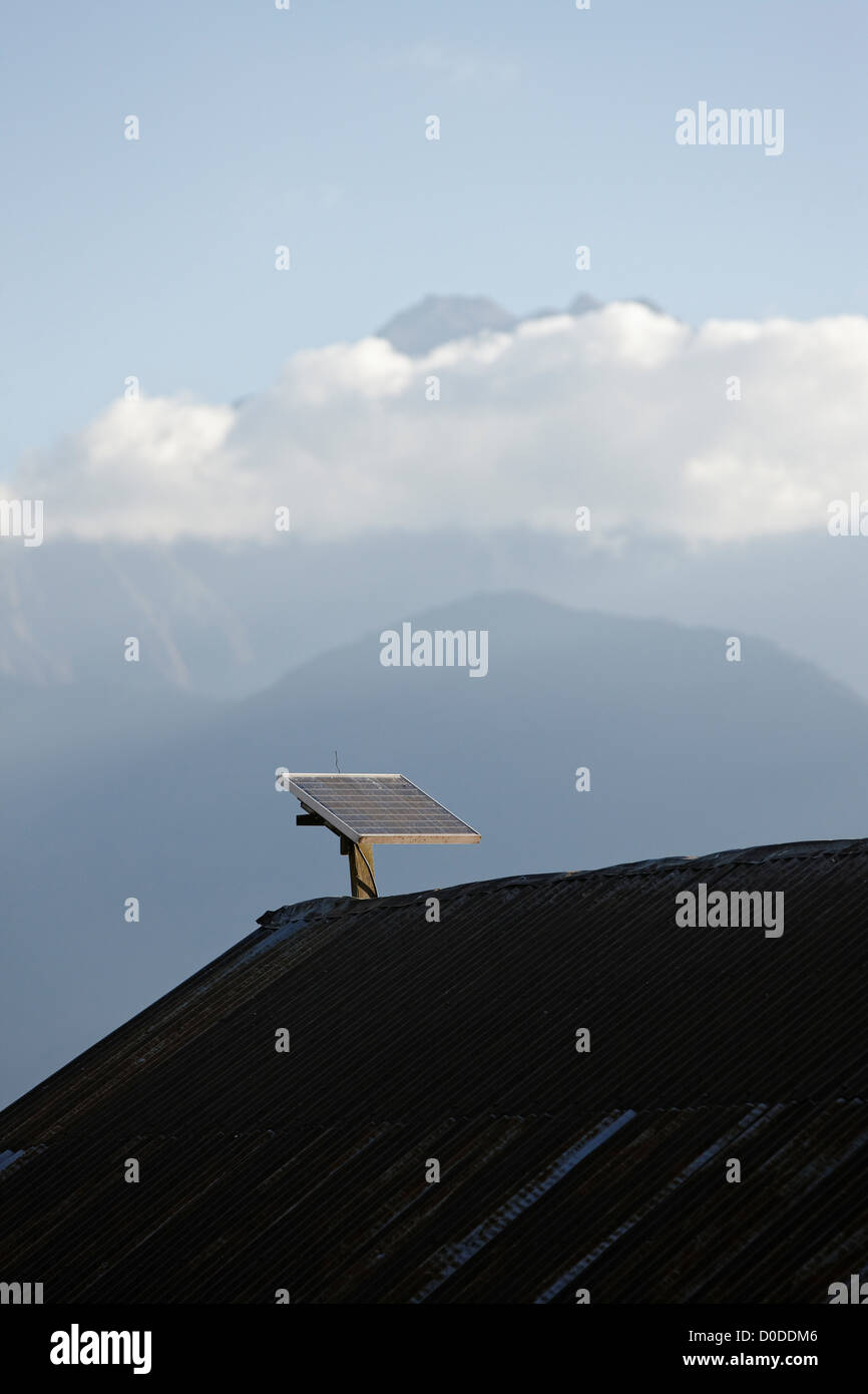 A small solar panel atop roof in Num Village in eastern Nepal enables ...