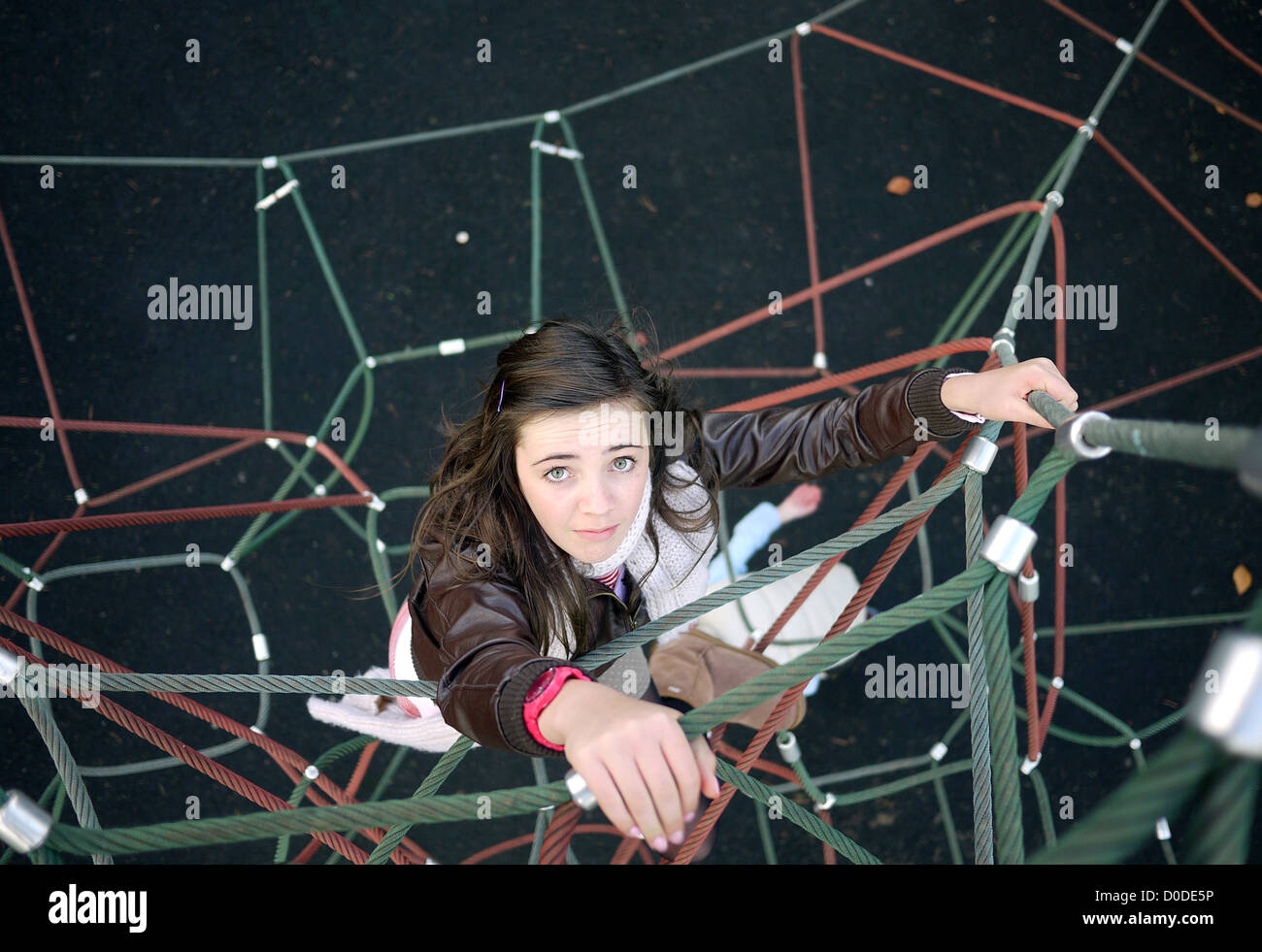 teenage girl climbing a rope frame Stock Photo - Alamy