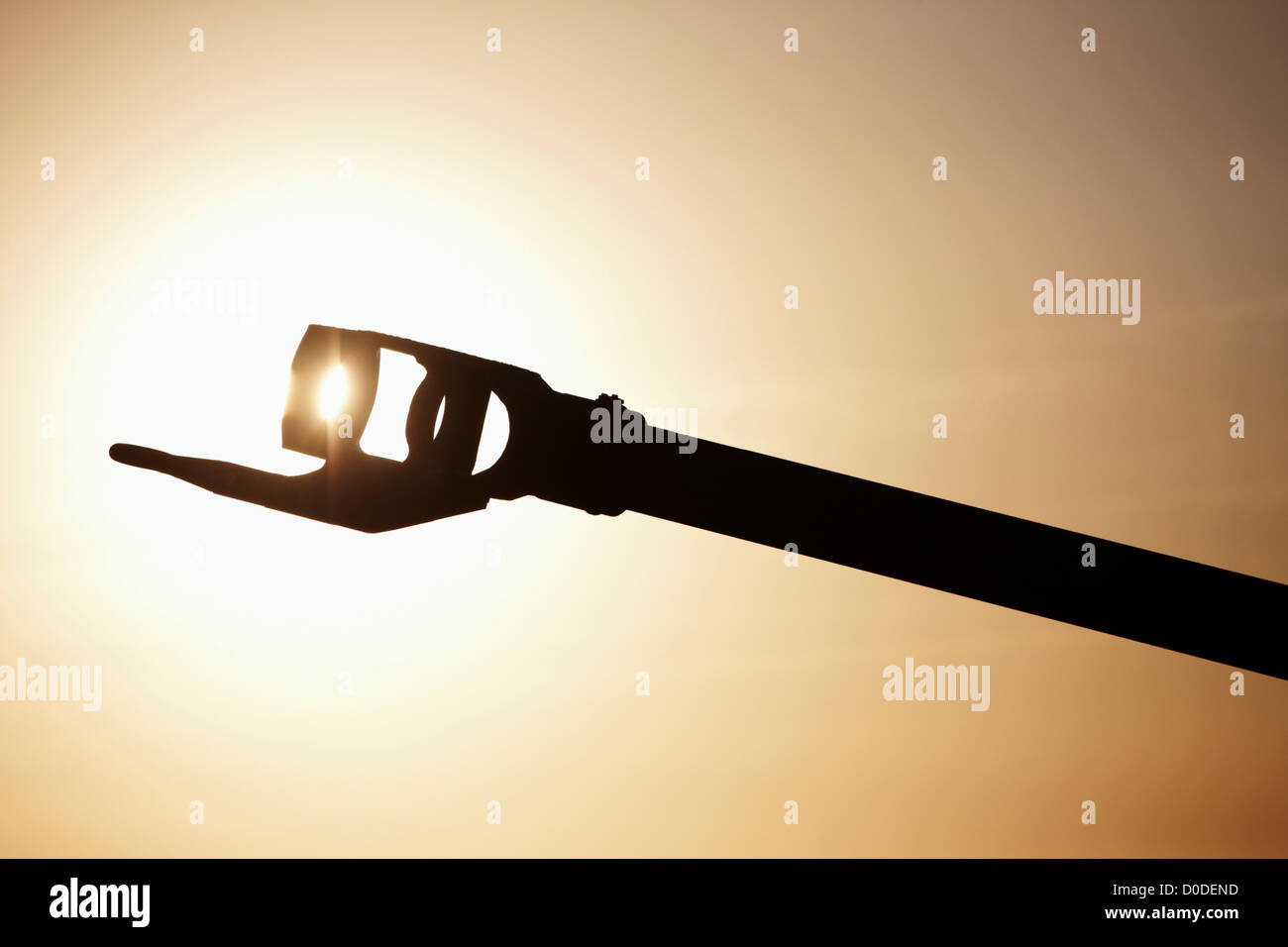 The rising sun silhouettes casts diffraction rays through muzzle brake ...