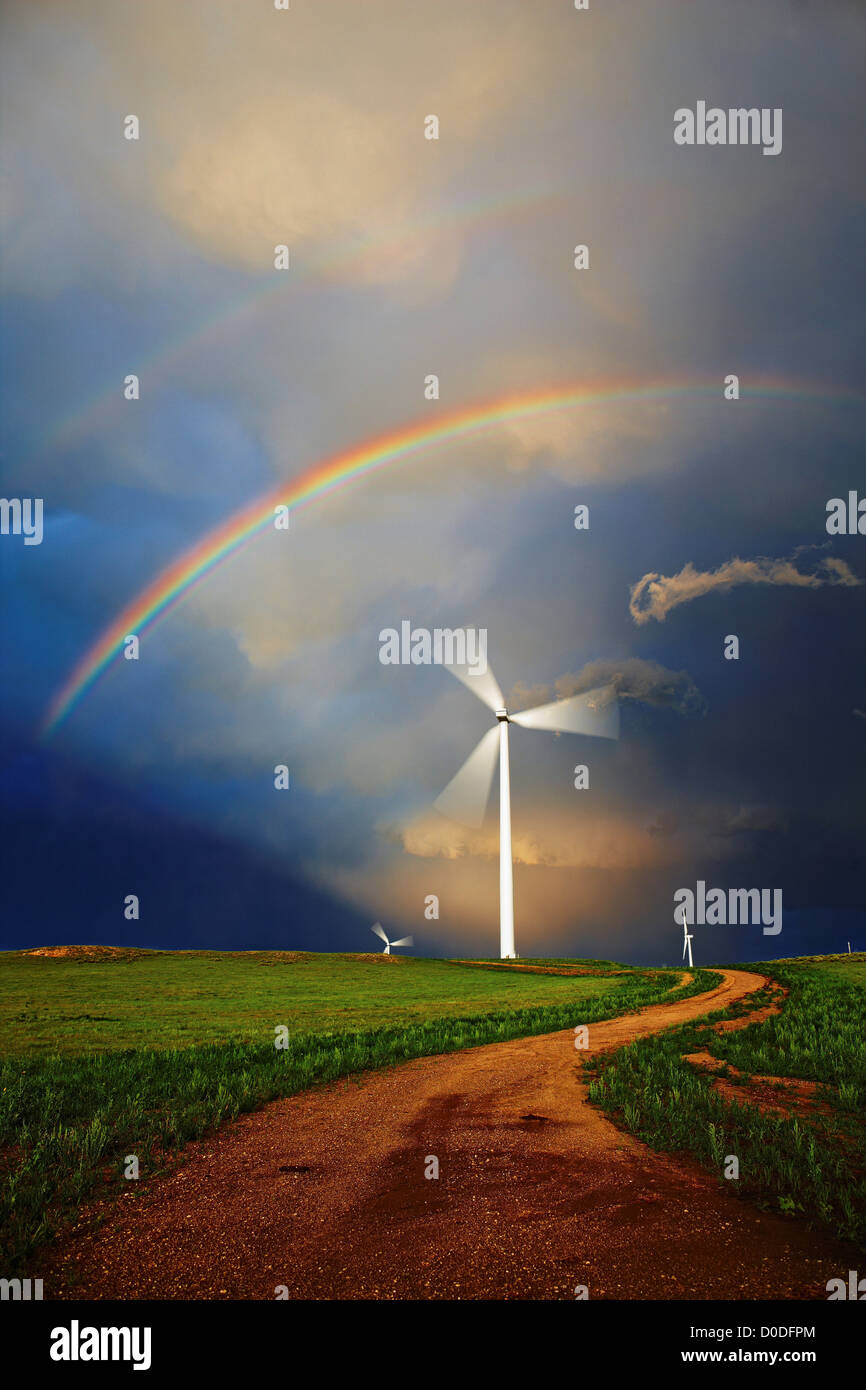 Winding road below spinning wind turbine and double rainbow Stock Photo ...