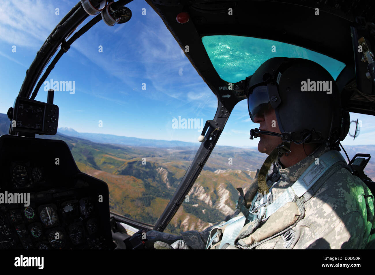 Cockpit view of a pilot of a Bell OH-58 Kiowa while flying above a deep ...