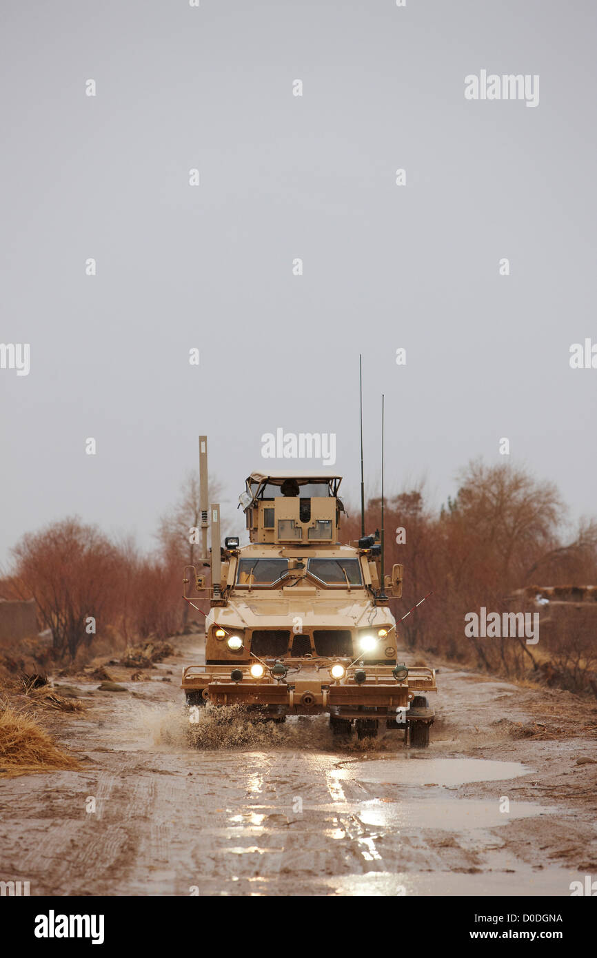 M-ATV, or Mine Resistant, Ambush Protected, All Terrain Vehicle, drives down muddy dirt road ...