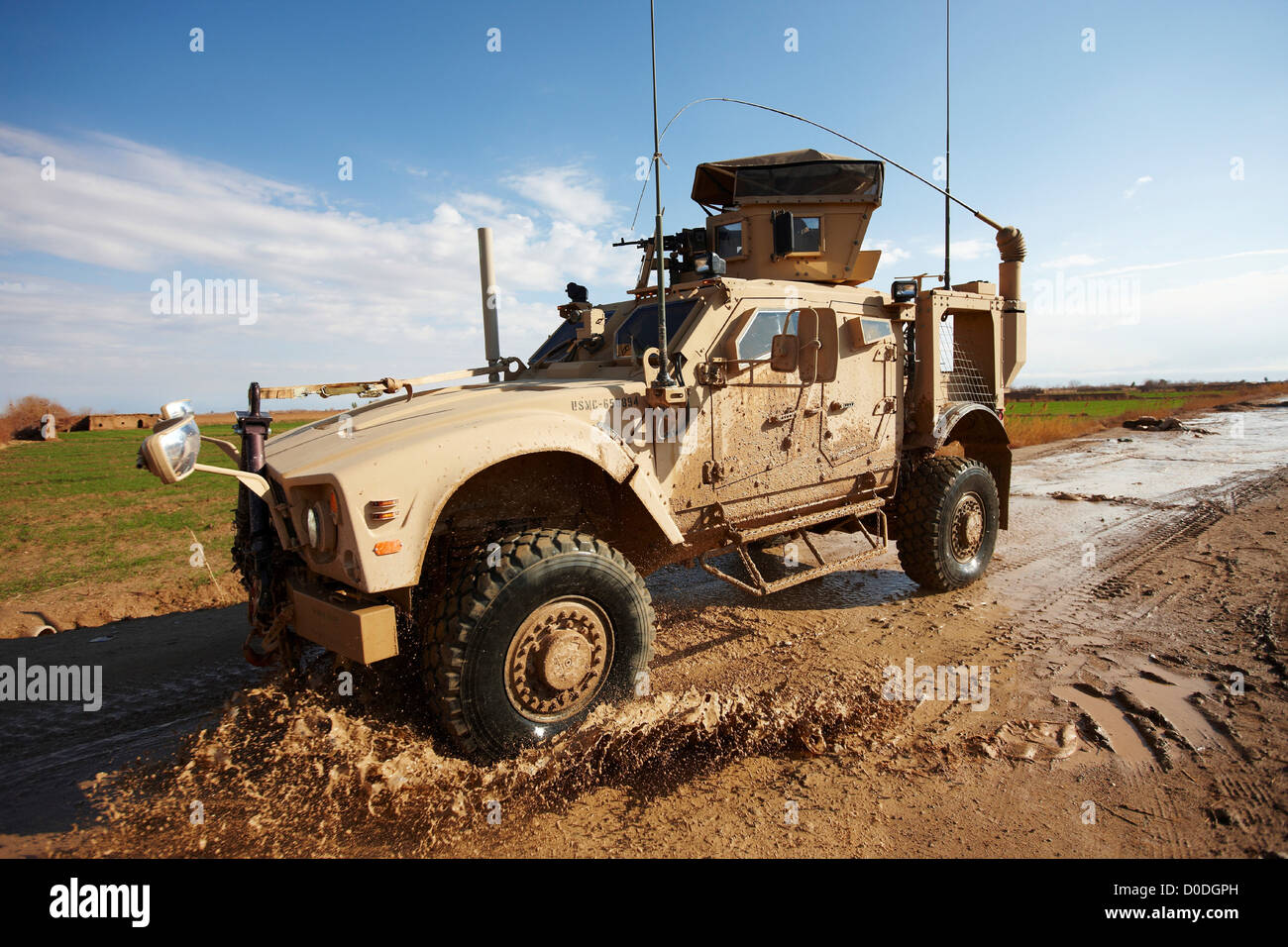 M-ATV or Mine Resistant Ambush Protected All Terrain Vehicle drives through puddles on muddy ...