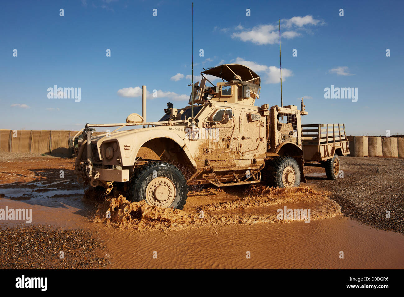 M-ATV or Mine Resistant Ambush Protected All Terrain Vehicle drives through puddles on muddy ...