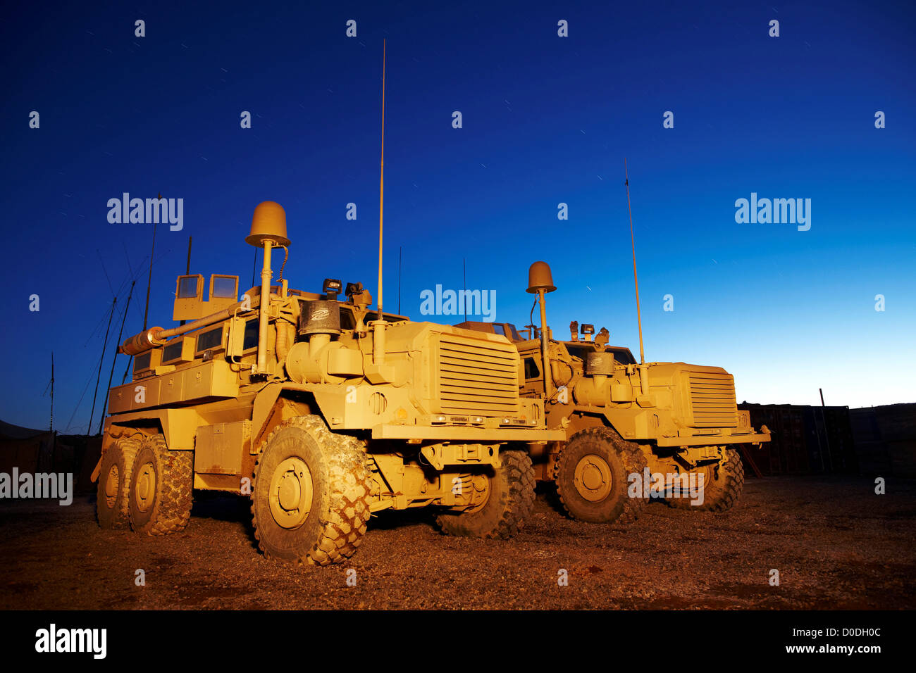 Night view two parked MRAPs or mine resistant ambush protected vehicles ...