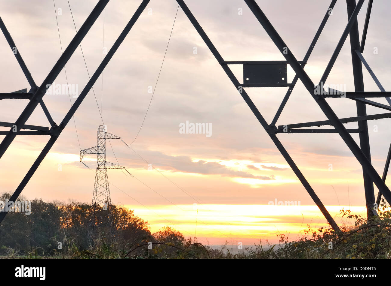 pylons through a metal structure overlooking the sunrise Stock Photo ...