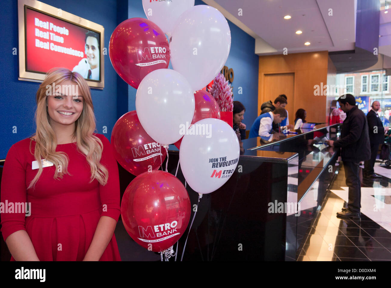 Staff members welcome customers at the new branch of Metro Bank in ...