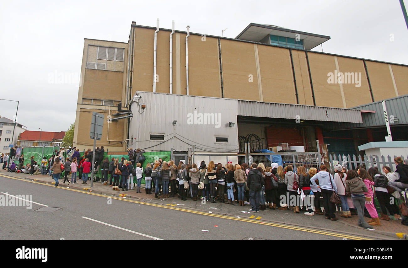 X Factor fans wait to catch a glimpse of the finalists behind a fence ...