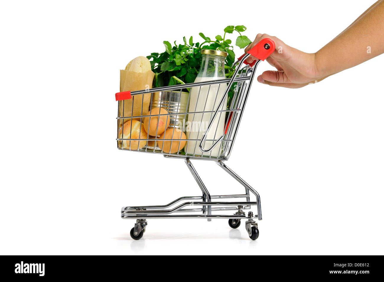 Hand pushing small shopping cart full with groceries isolated in white ...