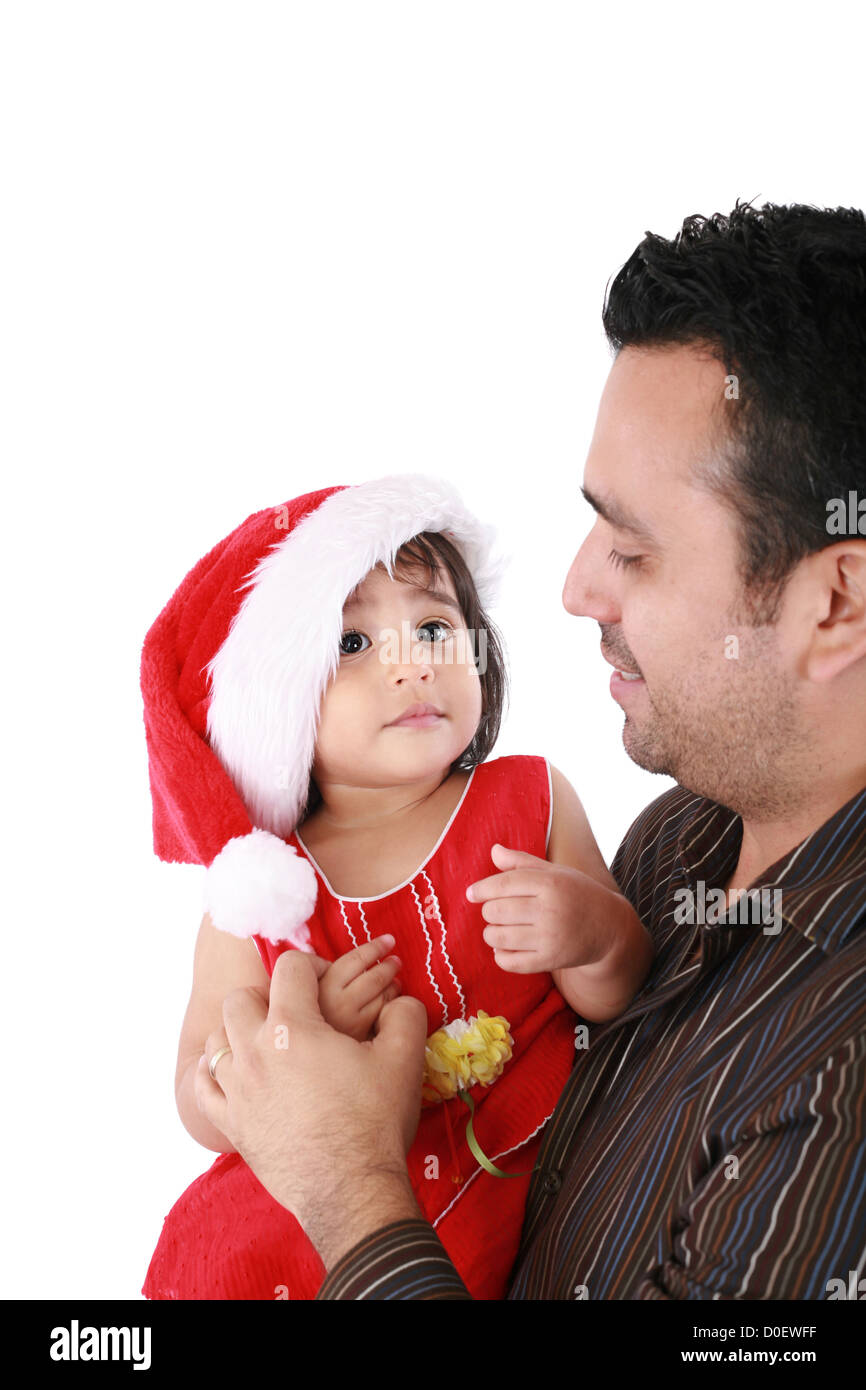 Father and daughter looking happy wearing santa Christmas hat. Focus on ...