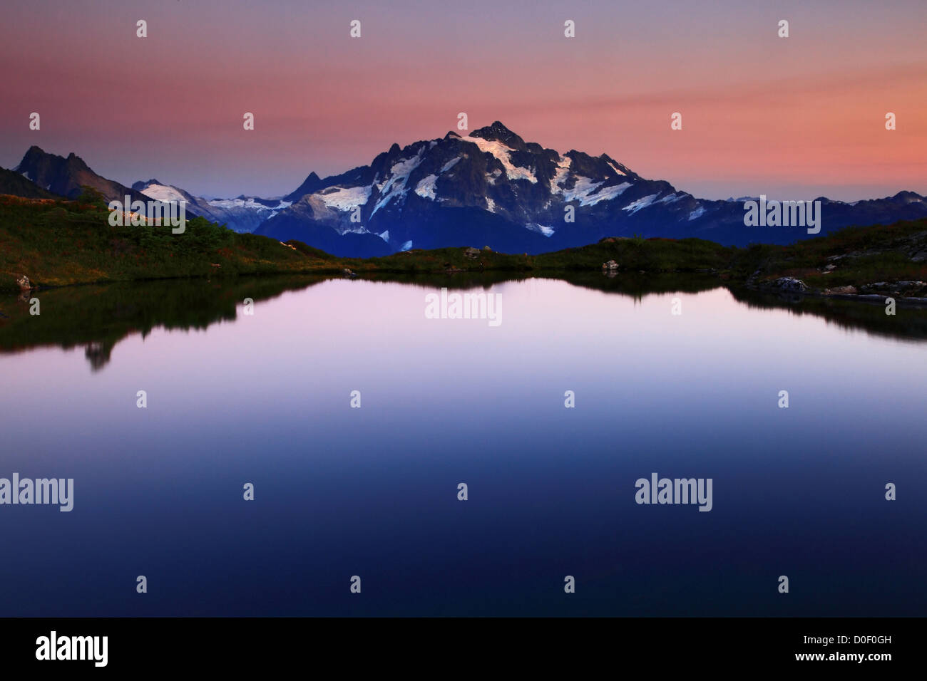 Sunset over a calm tarn with a view of Mount Shuksan from Yellow Aster ...
