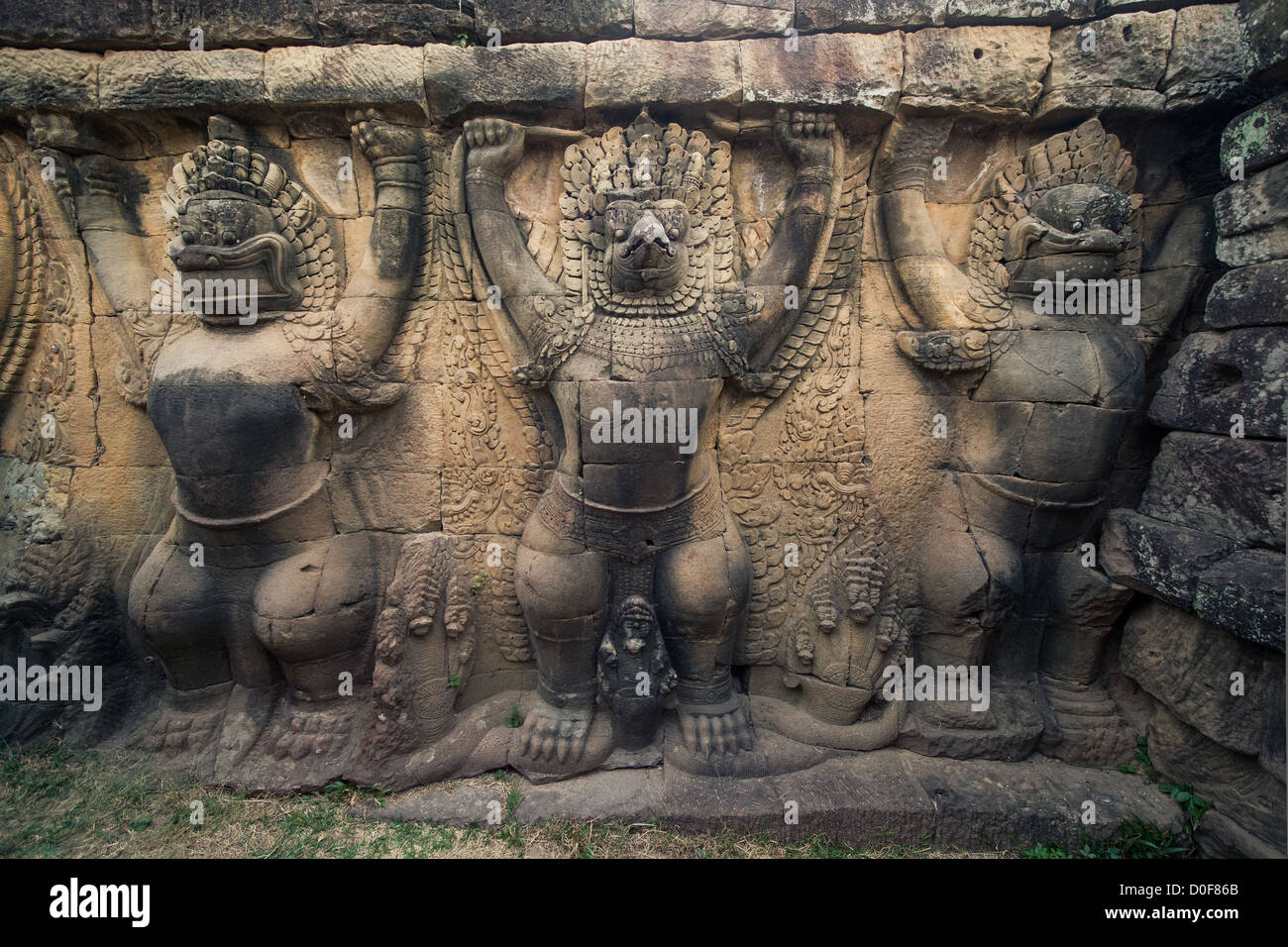 3 stone gods holding up a wall in Siem Reap, Cambodia Stock Photo - Alamy