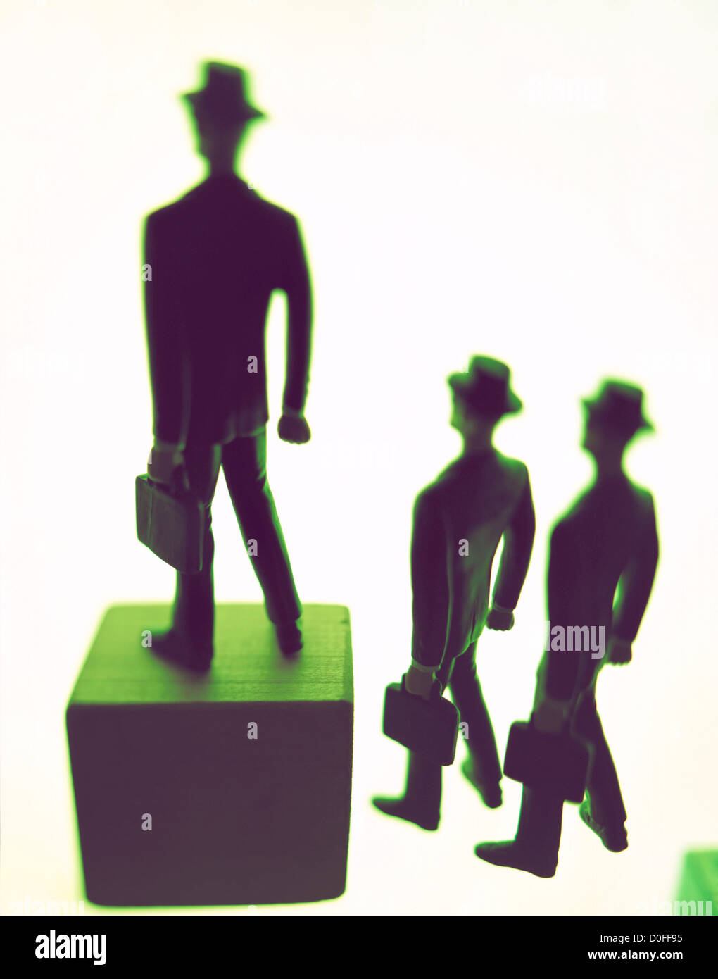 businessman with briefcase stepping up on a block above 2 men ...