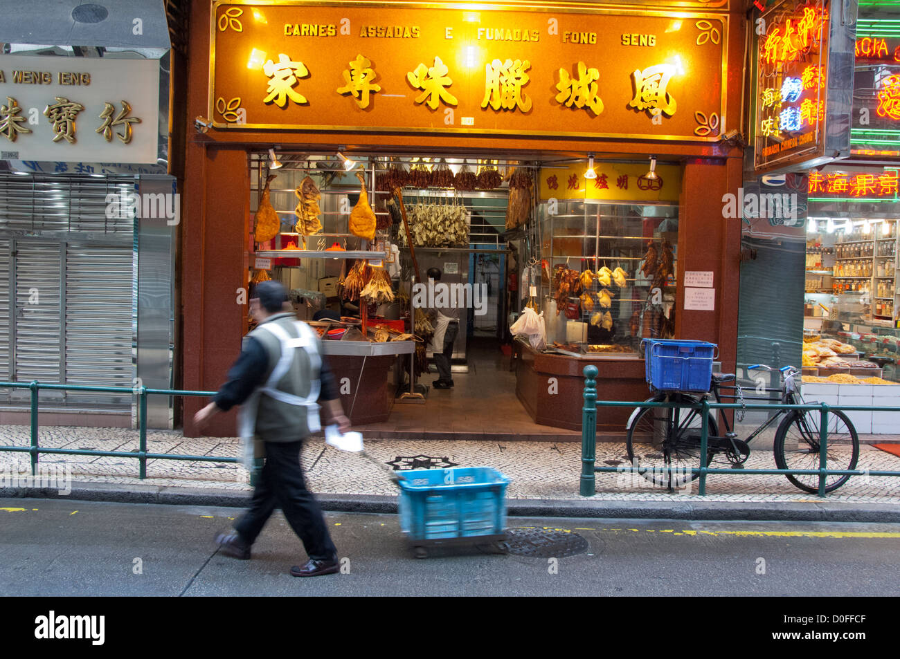 China, Macau. Traditional Chinese butcher shop. Man with delivery ...