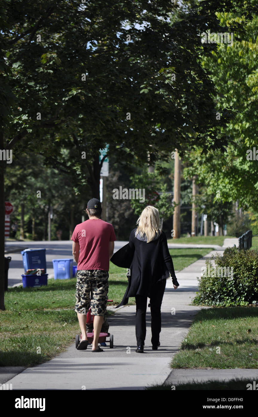 A young couple walks on a shady sidewalk, Ontario, Canada Stock Photo ...