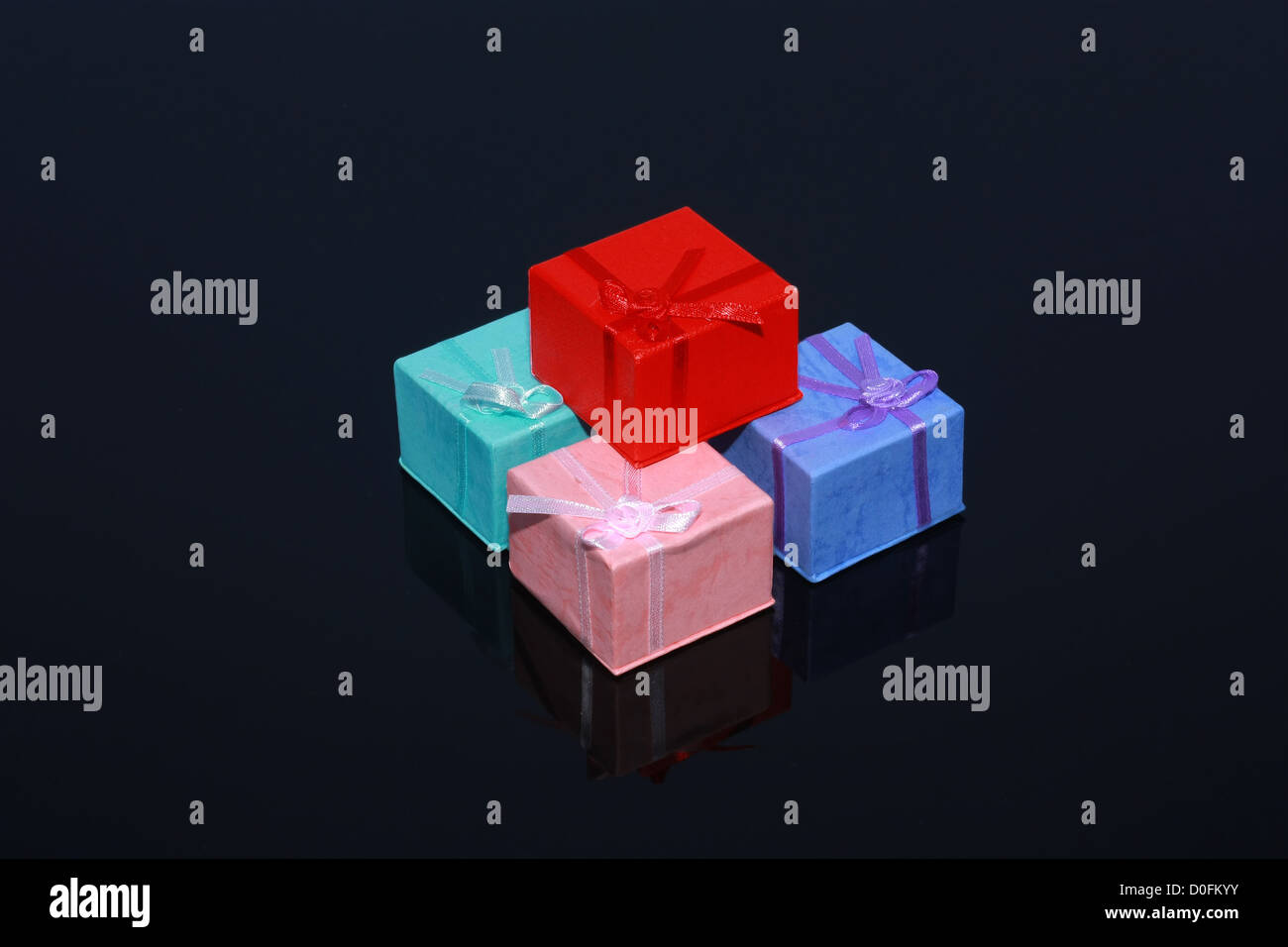 Four colorful gift boxes isolated on black background with reflection ...