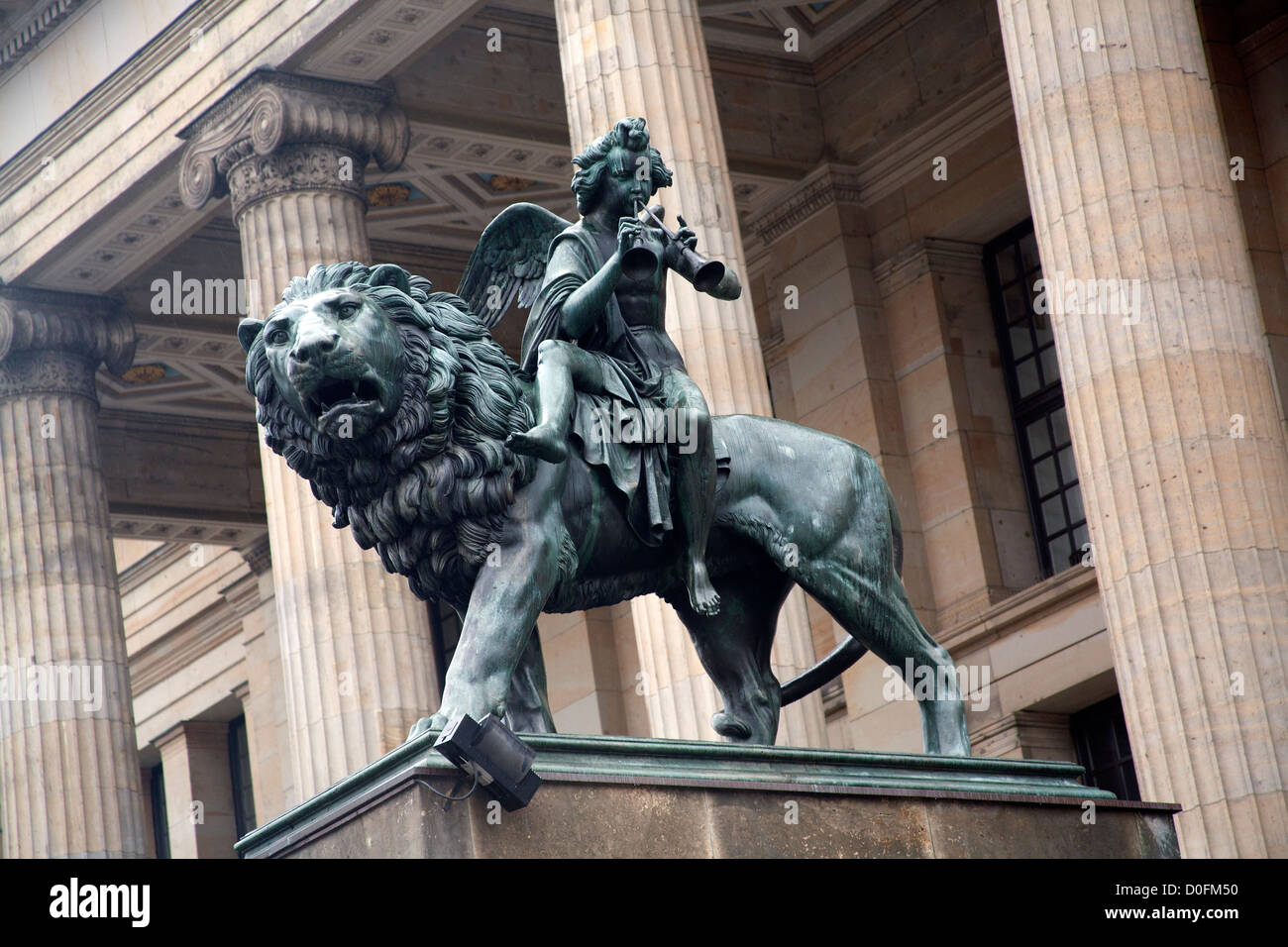 Statue of an angel sitting on the back of a lion on the portico of the ...