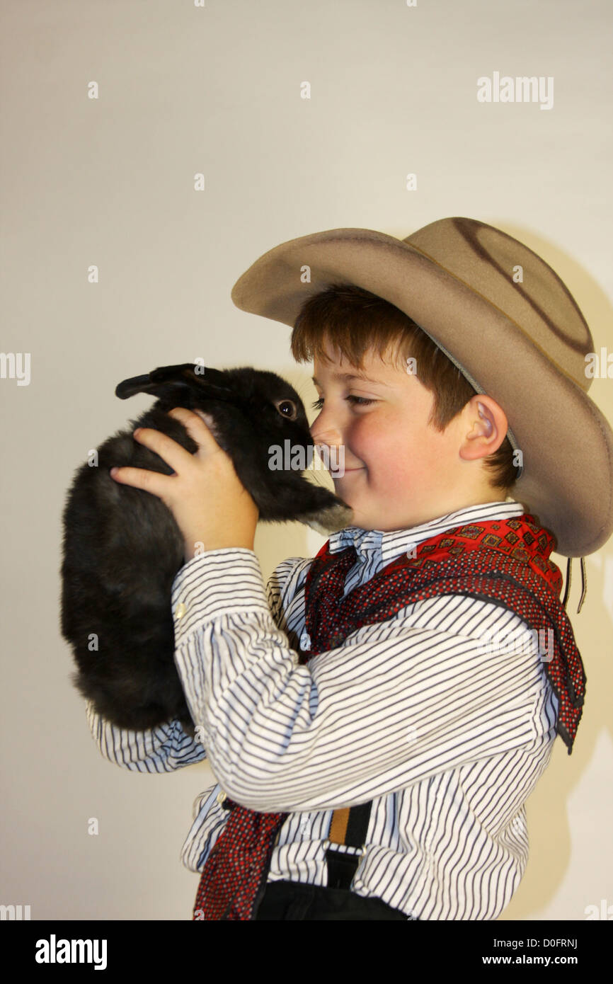 A young cowboy holding a black bunny rabbit Stock Photo - Alamy