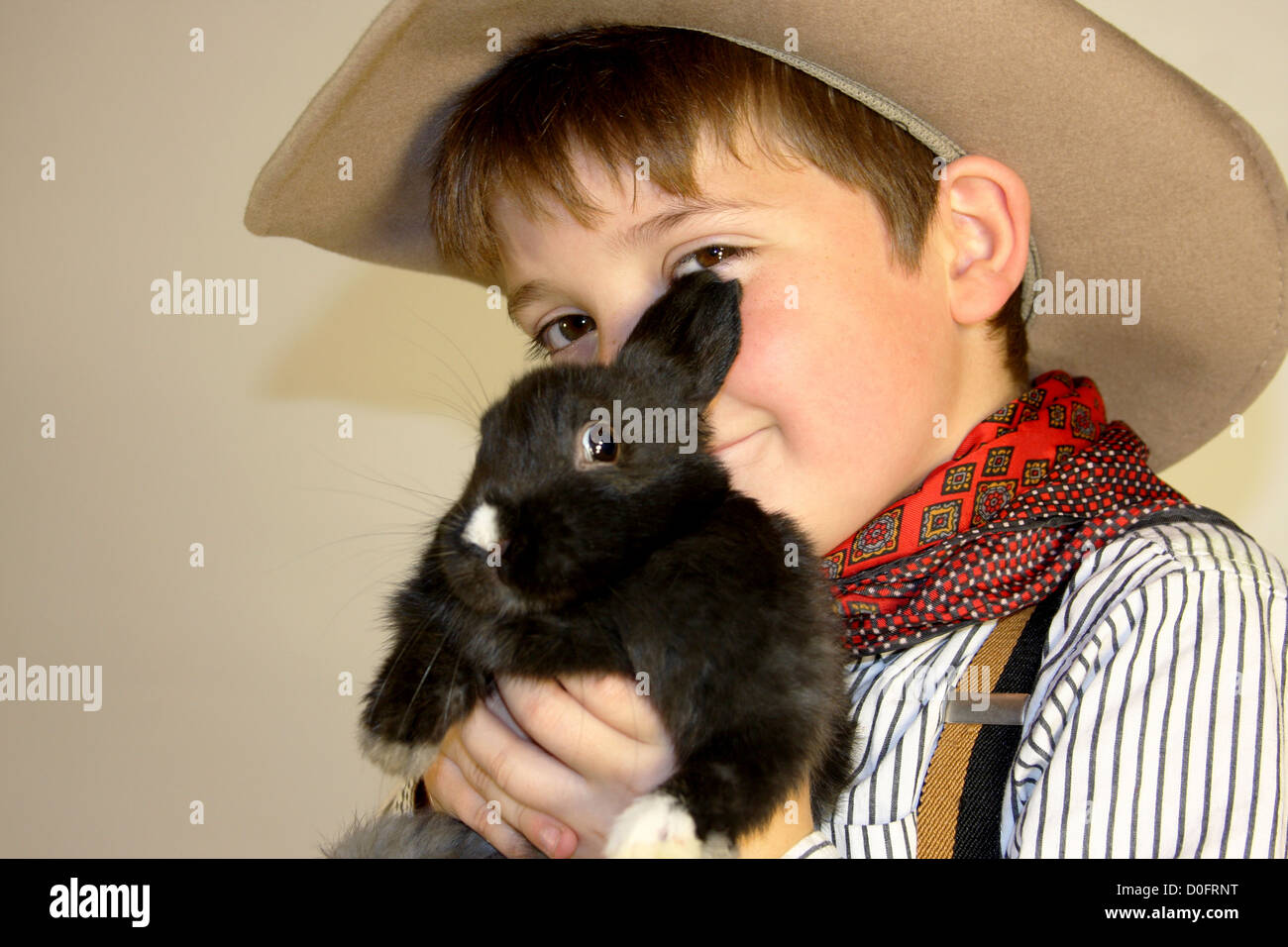 A young cowboy holding a black bunny rabbit Stock Photo - Alamy