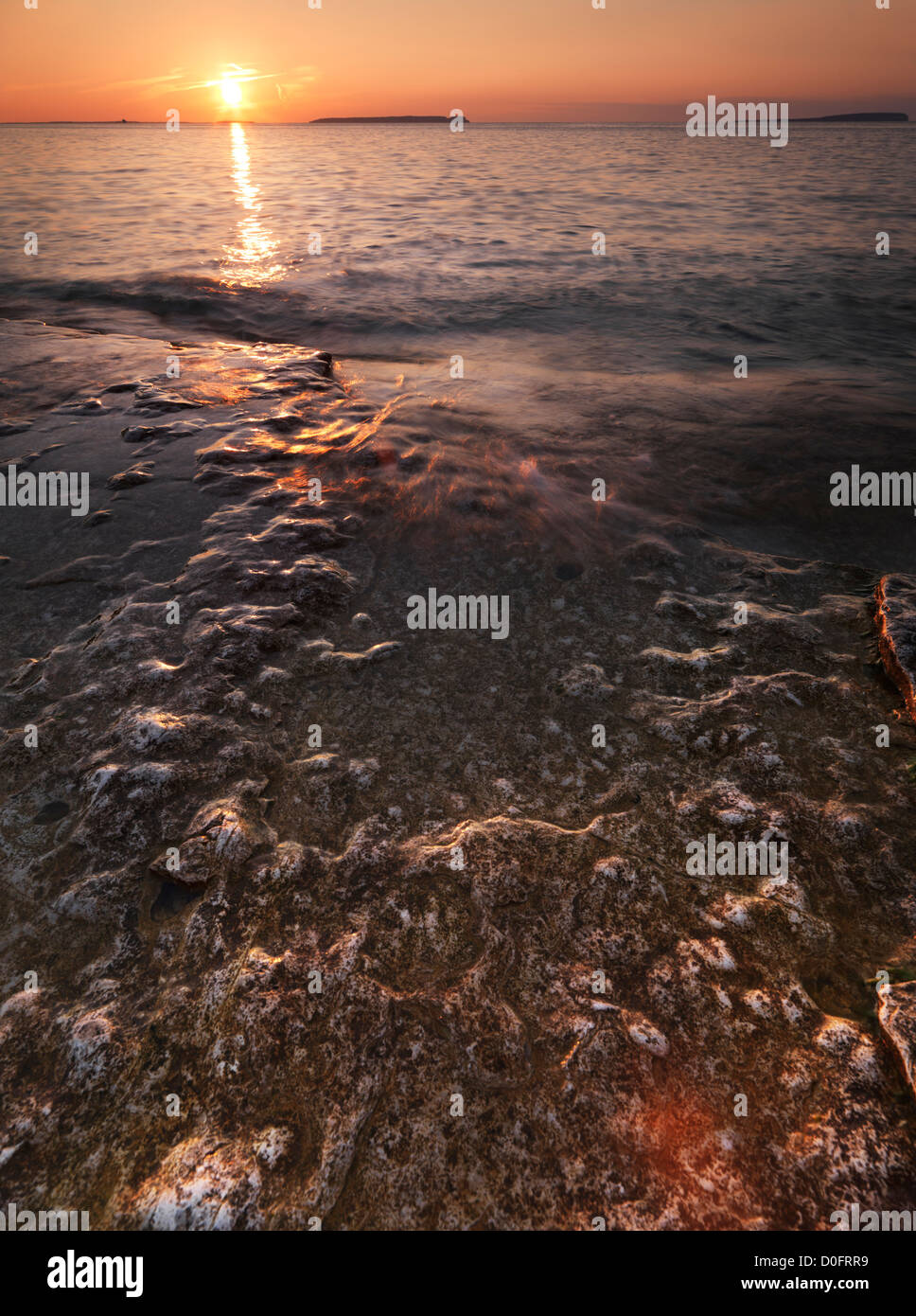 Sunset scenery of waves hitting rocks on a shore of Georgian Bay ...